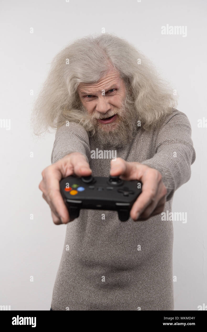 Nice joyful man holding a game console in front of him Stock Photo - Alamy