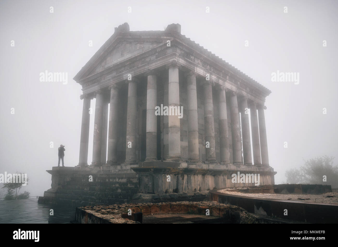 Garni hellenistic pagan Temple with silhouette of tourist taking photo ...