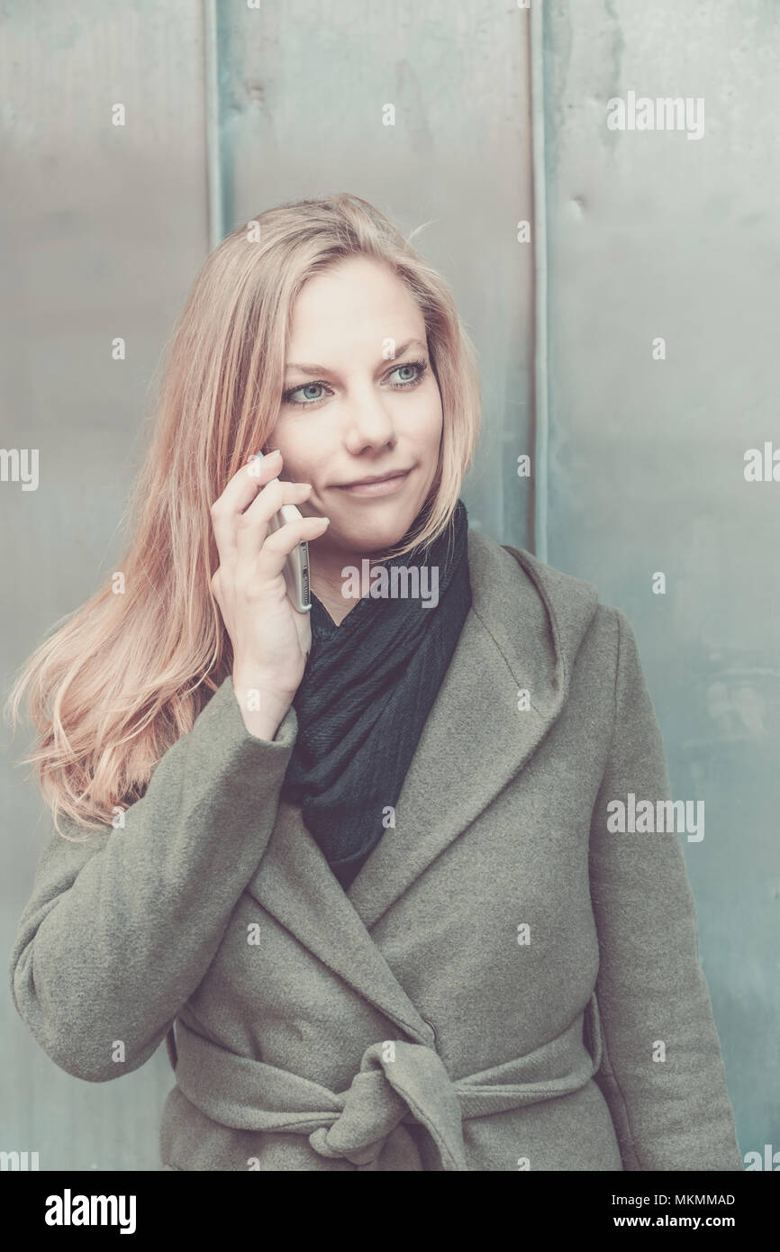 Young beautiful friendly woman wearing coat and black shawl using ...