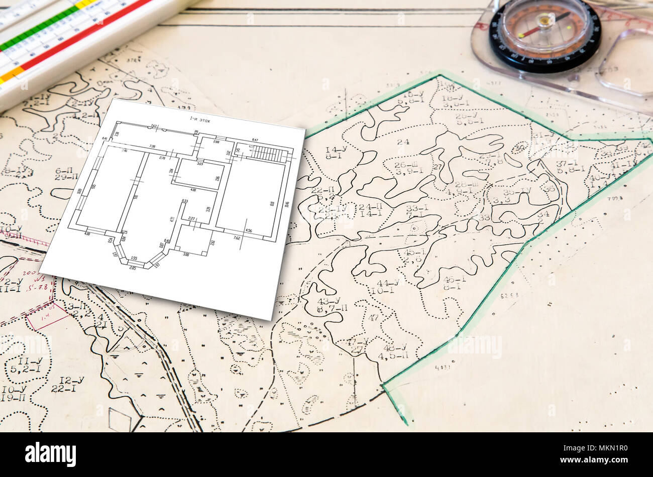 House design and plan of the land plot on the map. Near lie tools ...