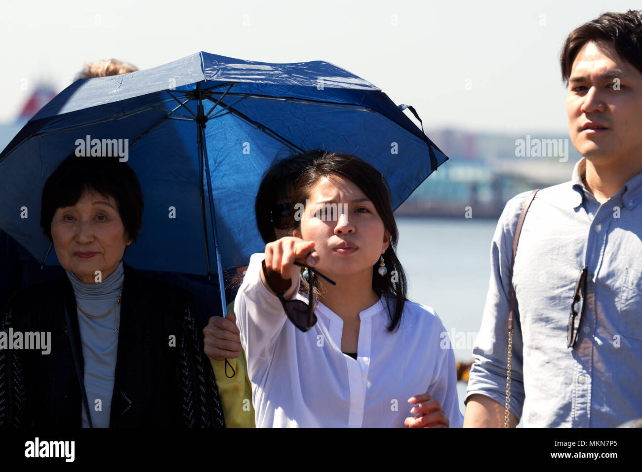 Woman appears to be pointing to the camera objecting to be photographed ...