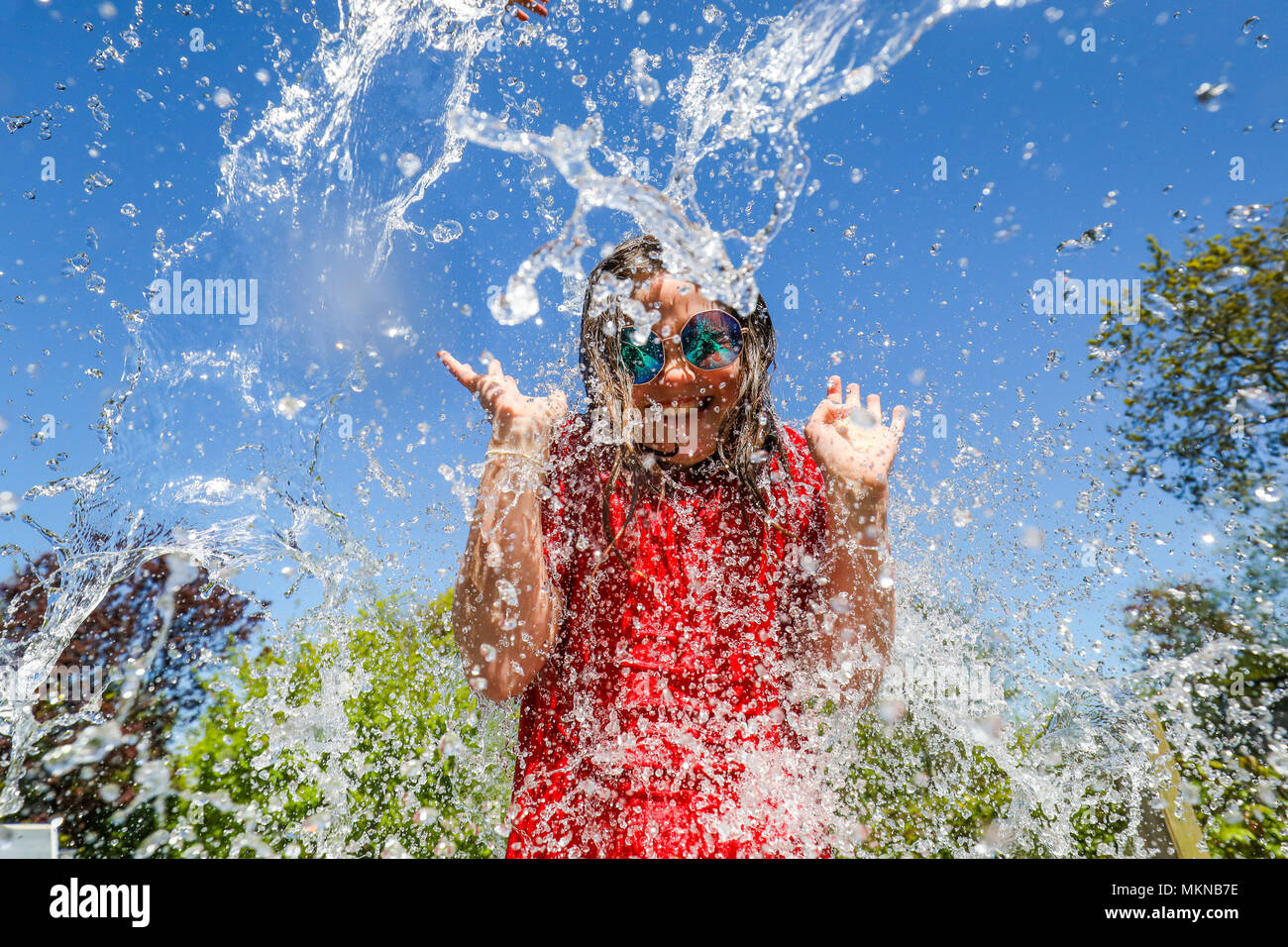 Waterfight splash in the garden in the UK summer Stock Photo - Alamy
