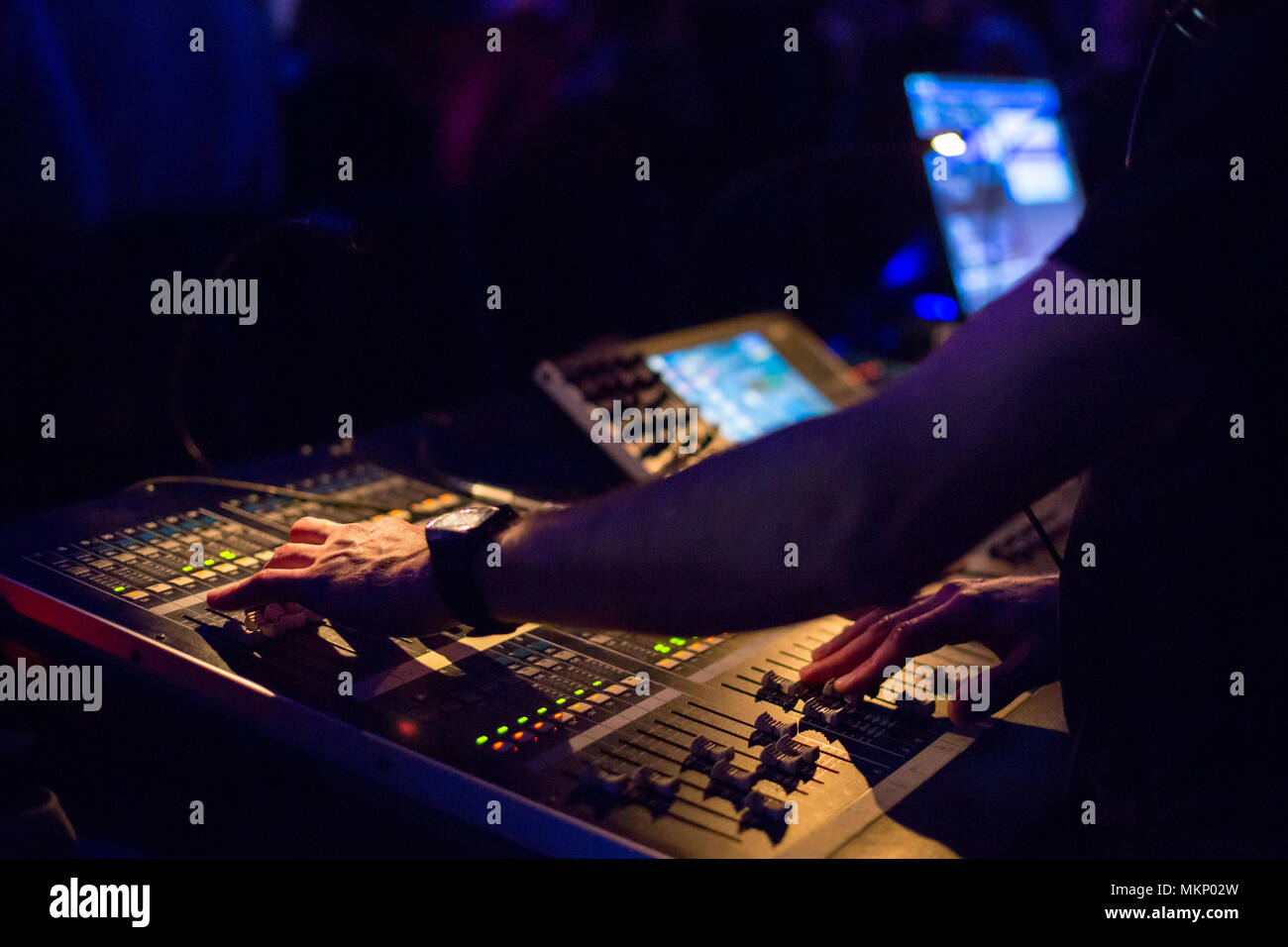 Soundman working on the mixing console in concert hall Stock Photo - Alamy