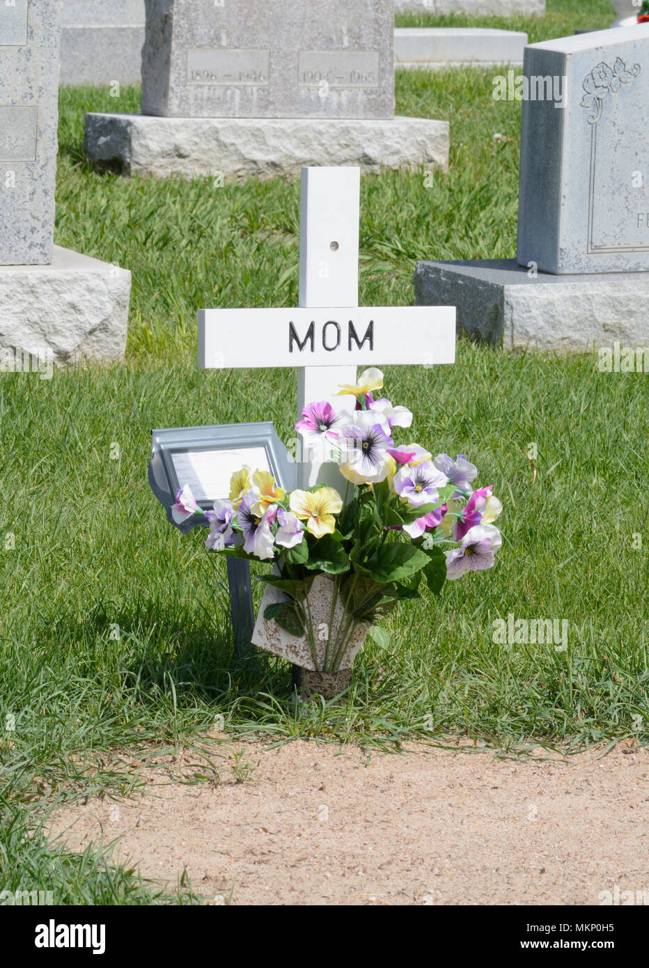 Simple white cross grave marker with all weather artificial flowers ...