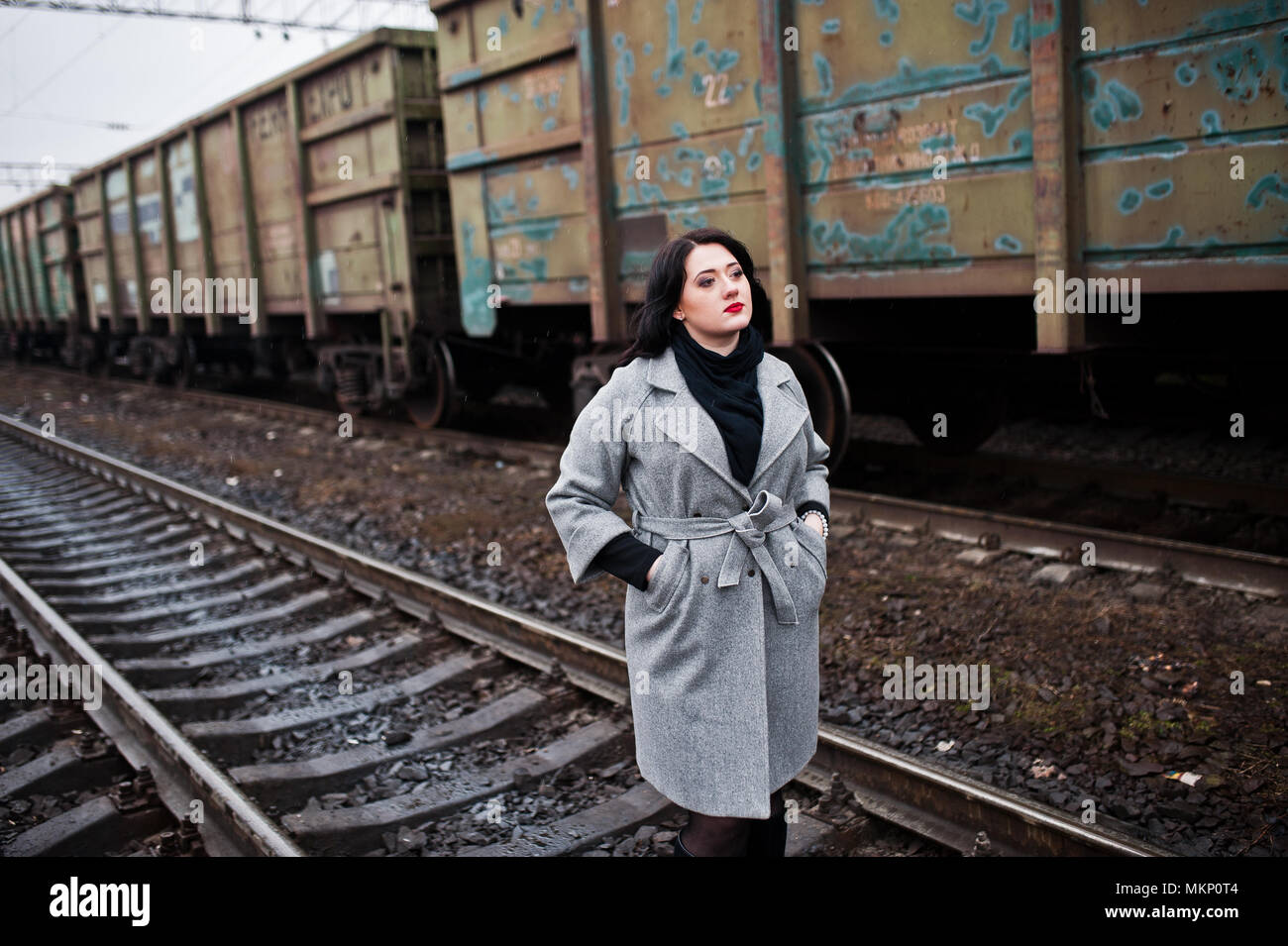 Brunette girl in gray coat posed in railway station Stock Photo - Alamy