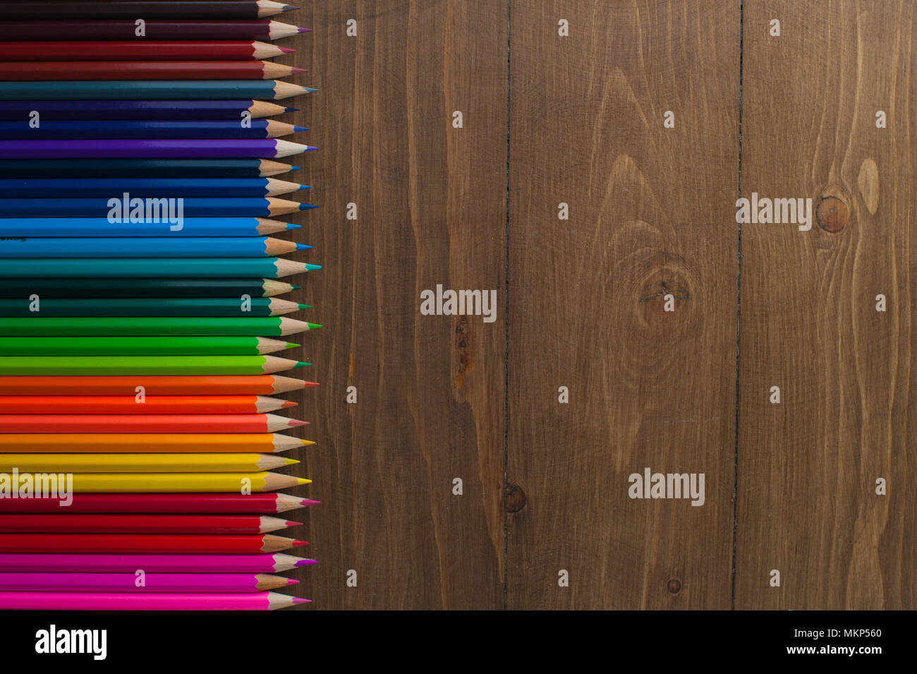 Colour pencils on wooden texture background Stock Photo - Alamy