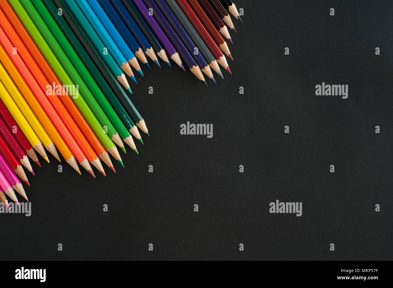Colour pencils on black texture background Stock Photo - Alamy
