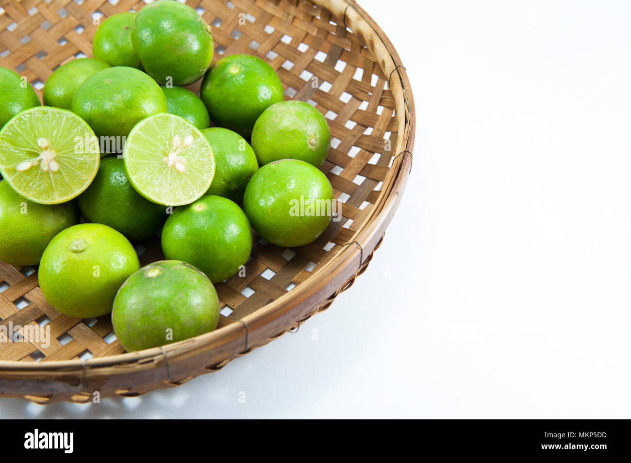 Closeup of fresh lime green slice in basket isolated on white ...