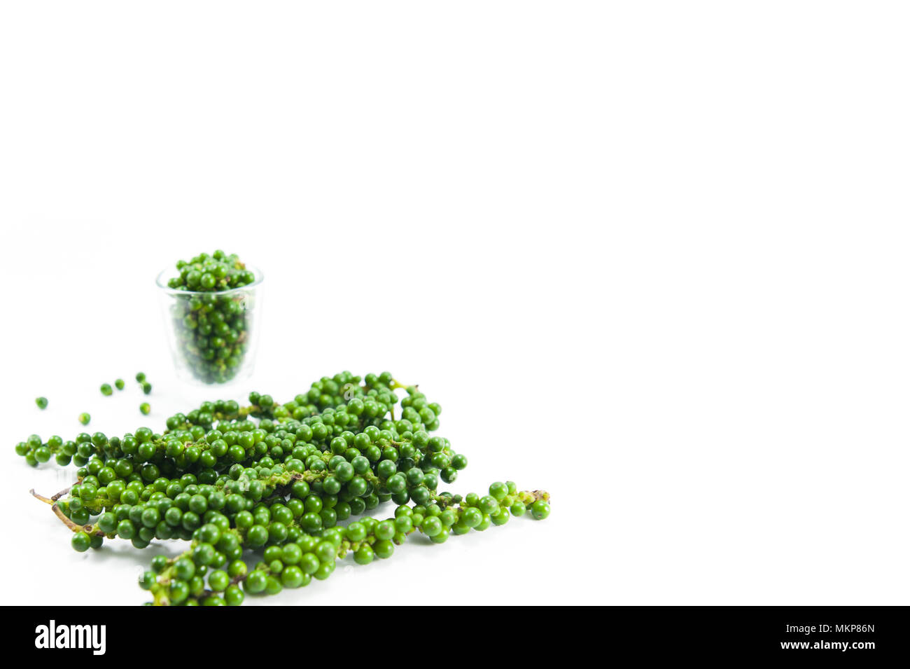 Fresh green pepper corn in glass on white background Stock Photo - Alamy