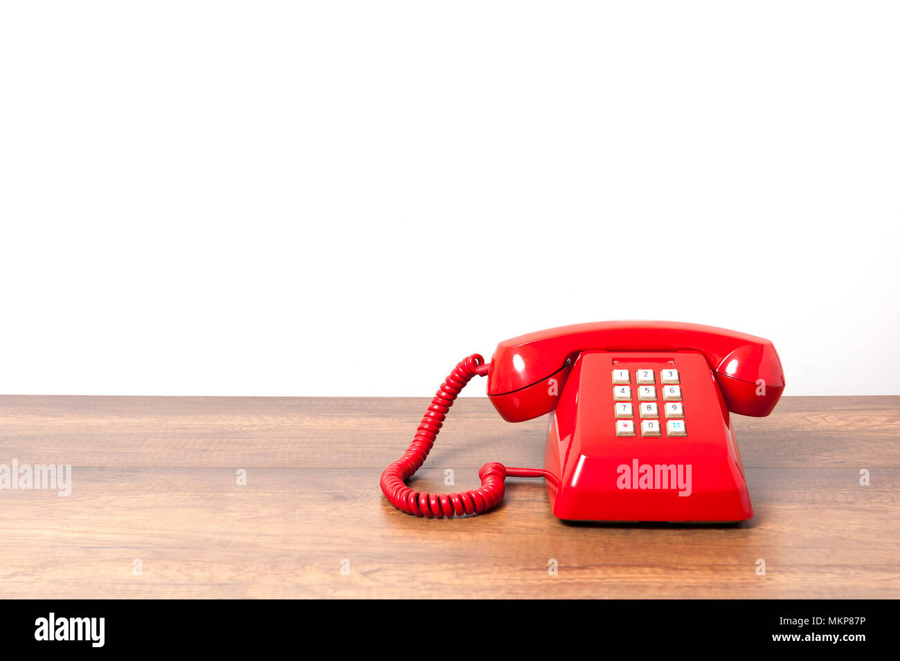 Retro red telephone on wood table on white wall background Stock Photo ...