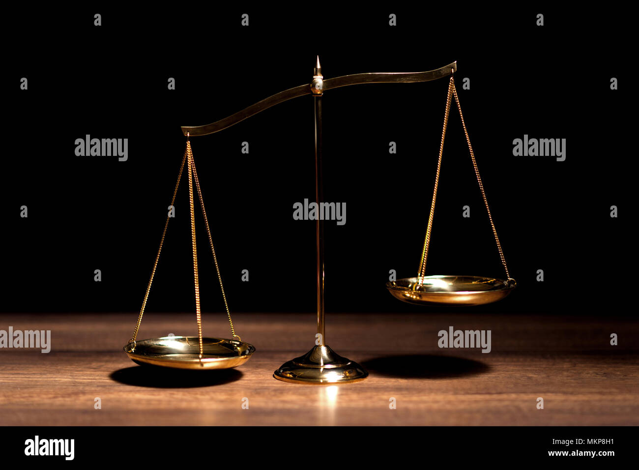 Gold brass balance scale on wooden table with black background Stock ...