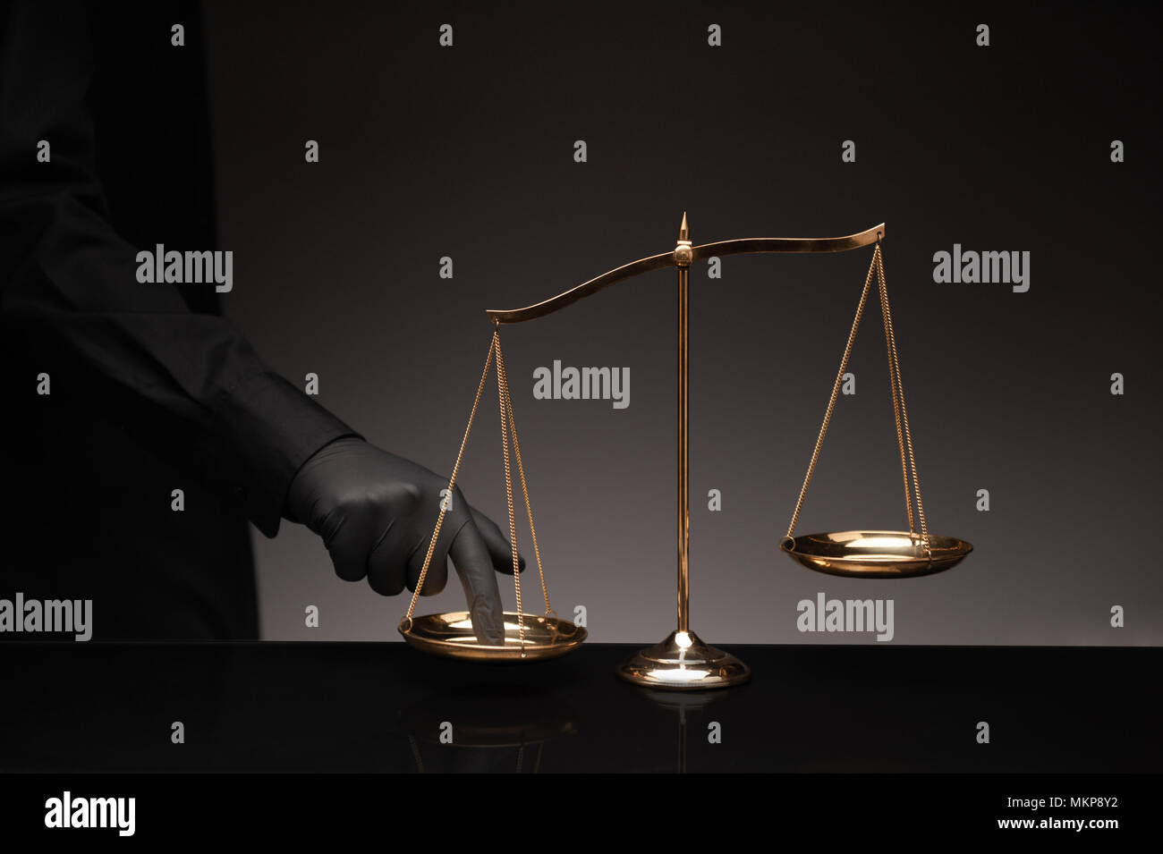 Man wearing black shirt pressing the imbalance scale on black glass ...