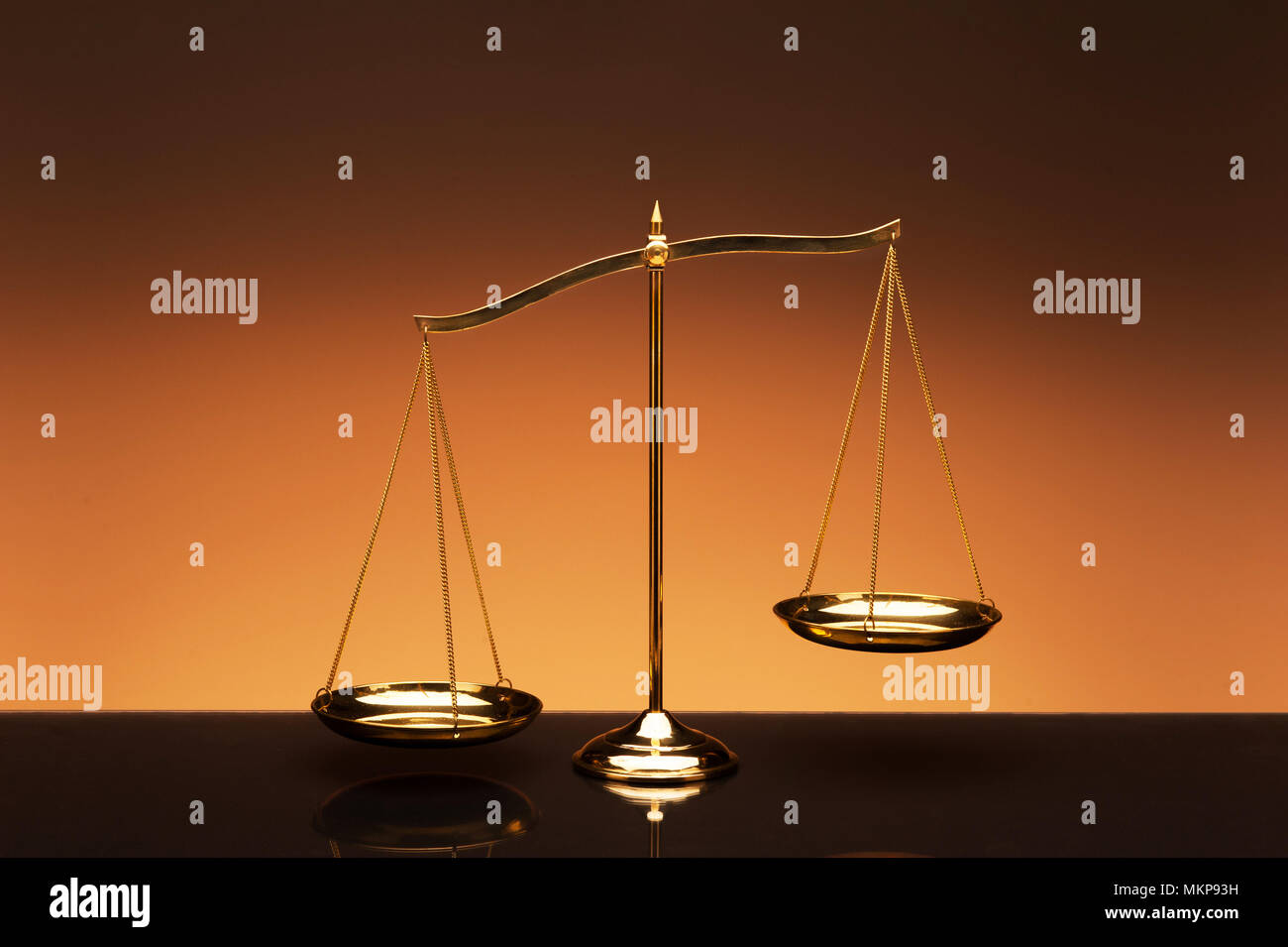 Golden brass balance or imbalance scale on orange color background ...