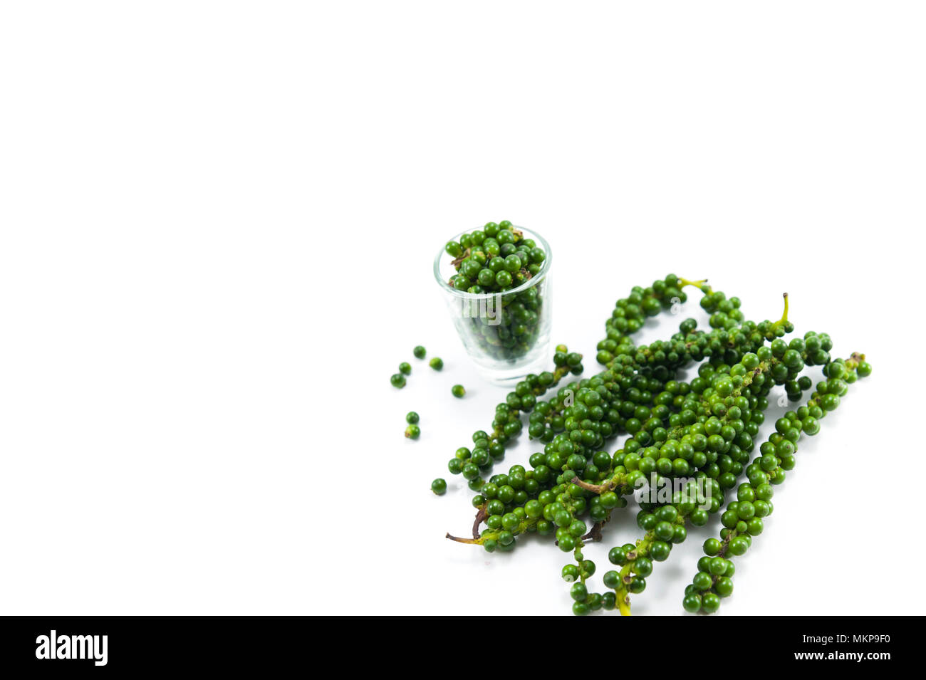 Fresh green pepper corn in glass on white background Stock Photo - Alamy