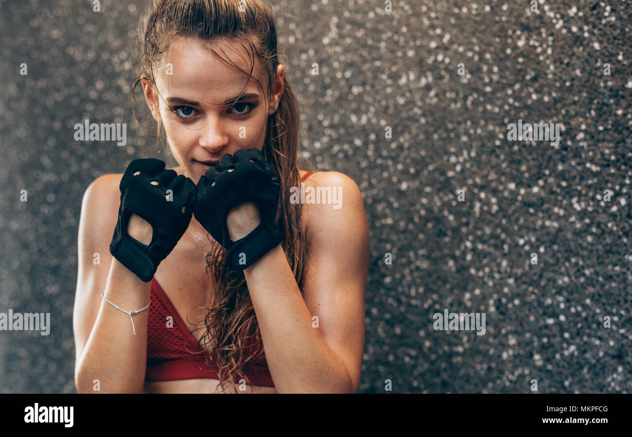 Young woman standing in fighting stance. Female boxer exercising ...