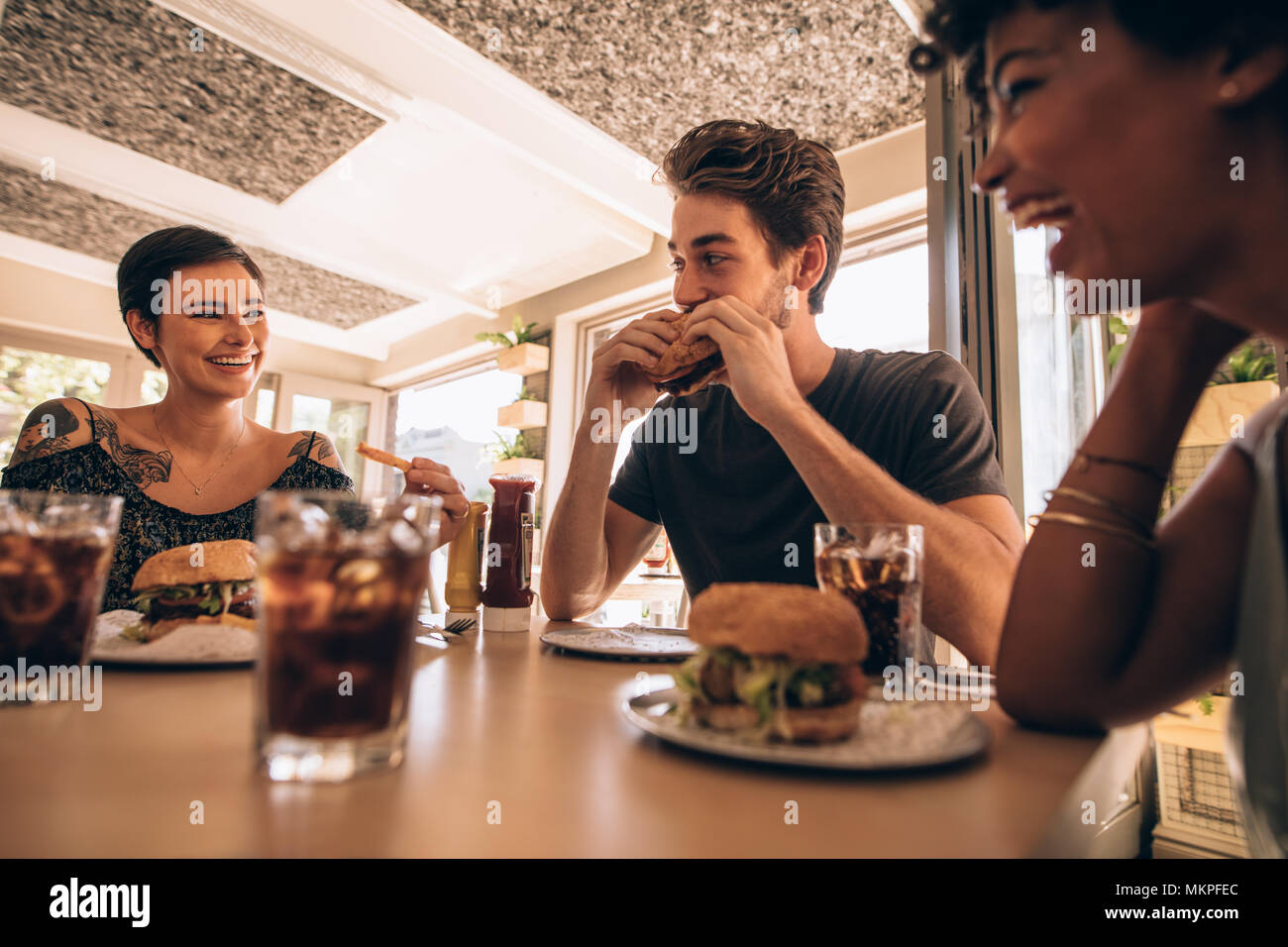 Group of friends meeting at a fast food restaurant. Man and women ...
