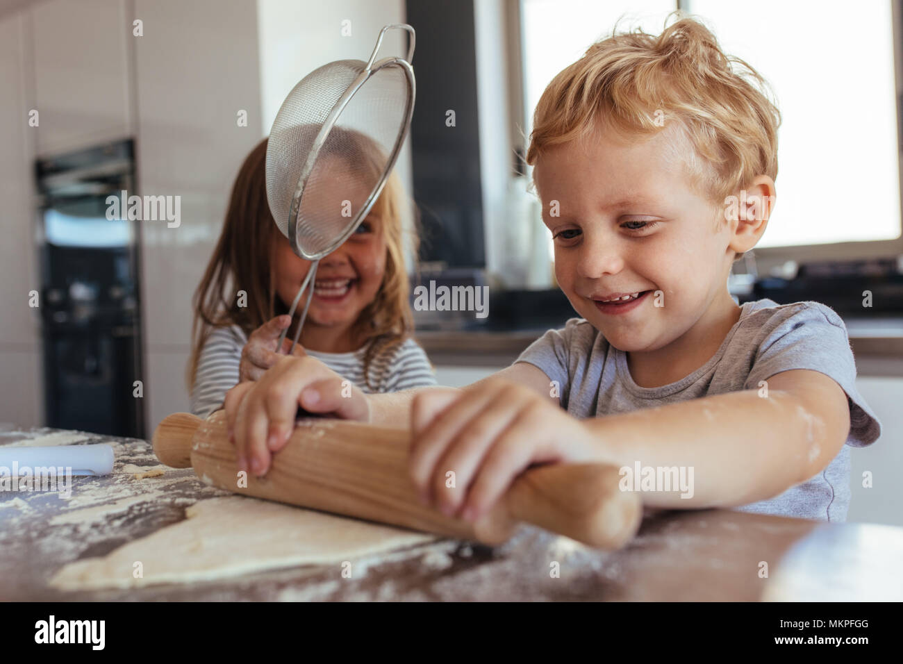 Children cooking cookies and having fun in the kitchen. Little boy and ...