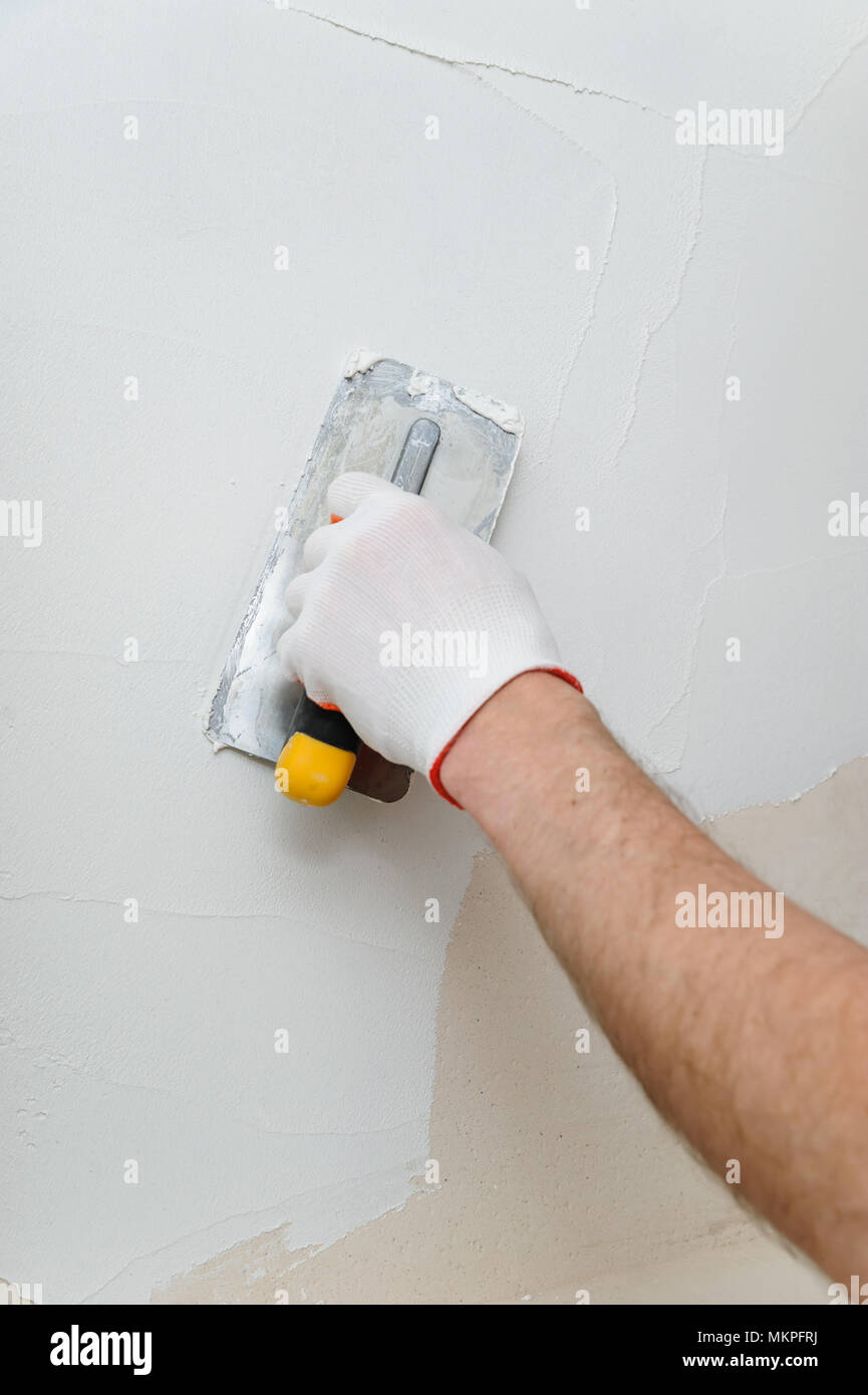 Decorative plaster coating. Man puts plaster on the wall Stock Photo ...