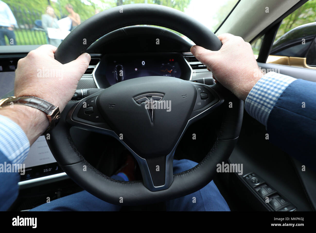 Dan Kiely, CEO of Voxpro, holds the wheel of his Tesla Model S car at a ...