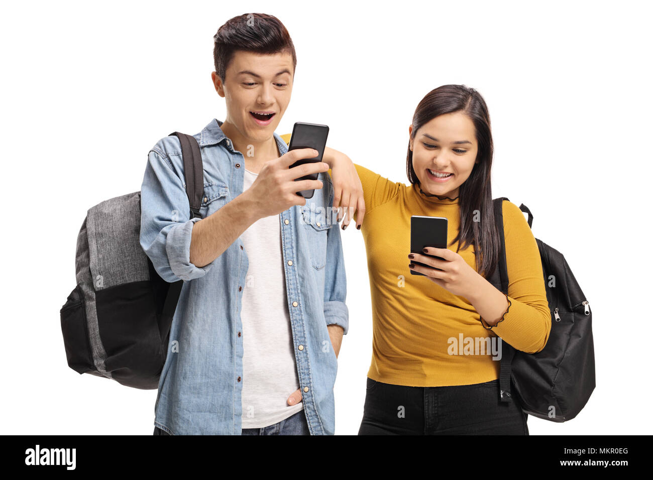 Cheerful teenage students using phones isolated on white background ...
