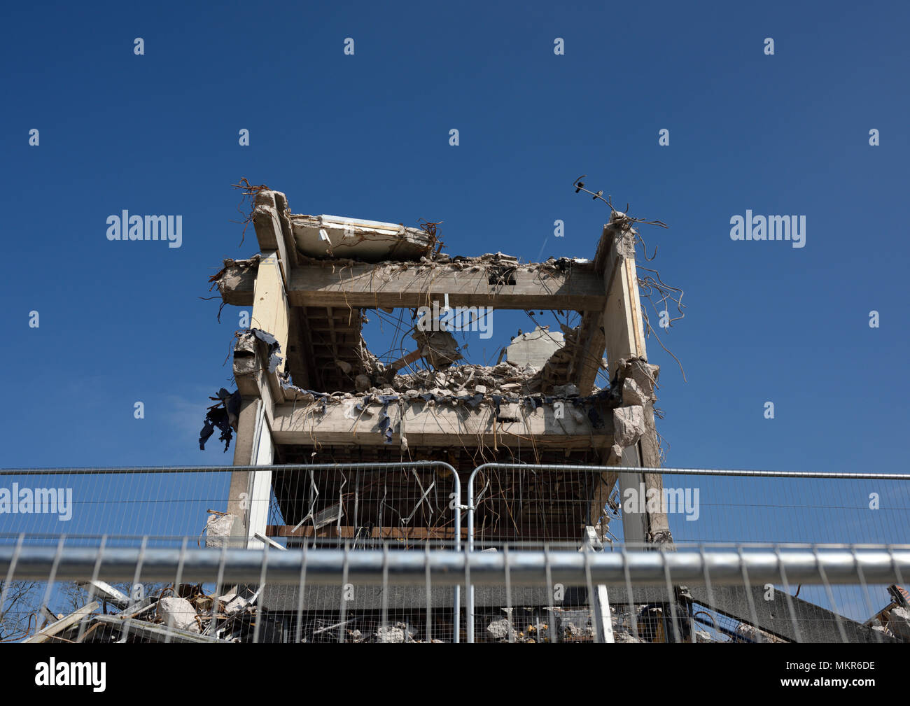 Safety barrier in front of partly demolished reinforced concrete multi ...