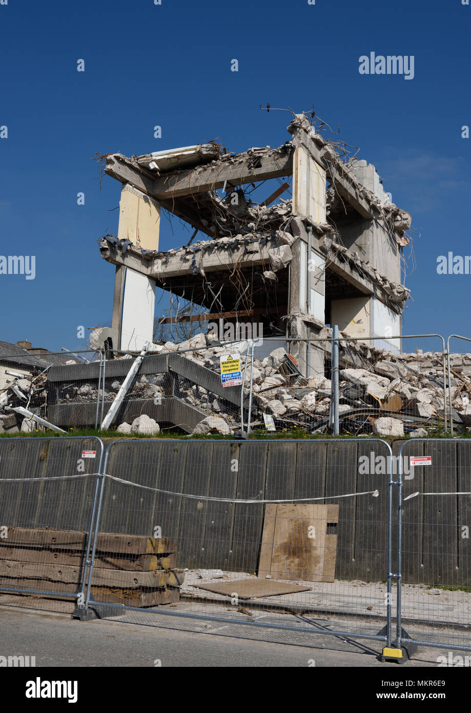 Safety barrier in front of partly demolished reinforced concrete multi ...