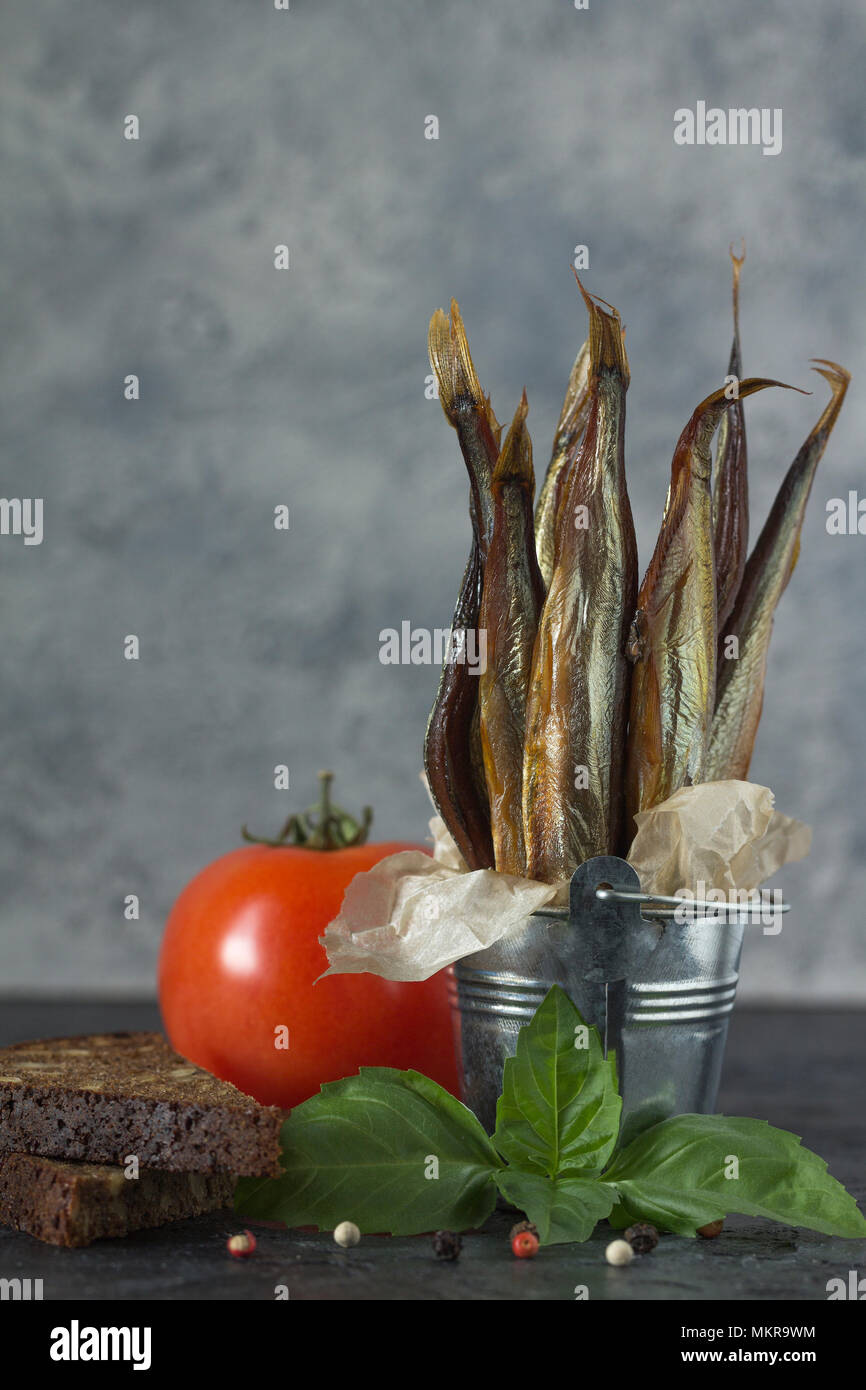 Capelin cold smoked fish in a decorative bucket on a black and gray ...