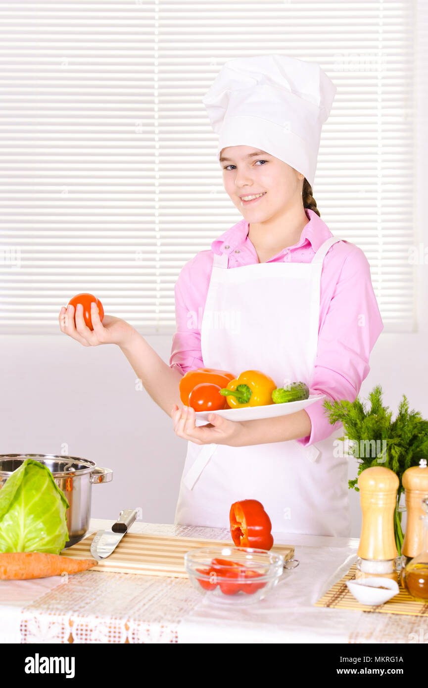 beautiful girl wearing chef uniform with vegetables on kitchen Stock ...