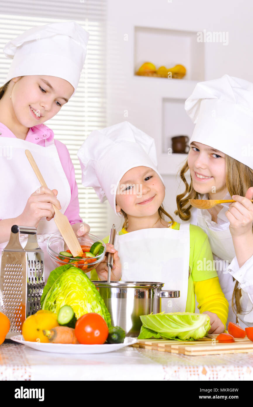 happy cute girls cooking vegetable dish on kitchen Stock Photo - Alamy
