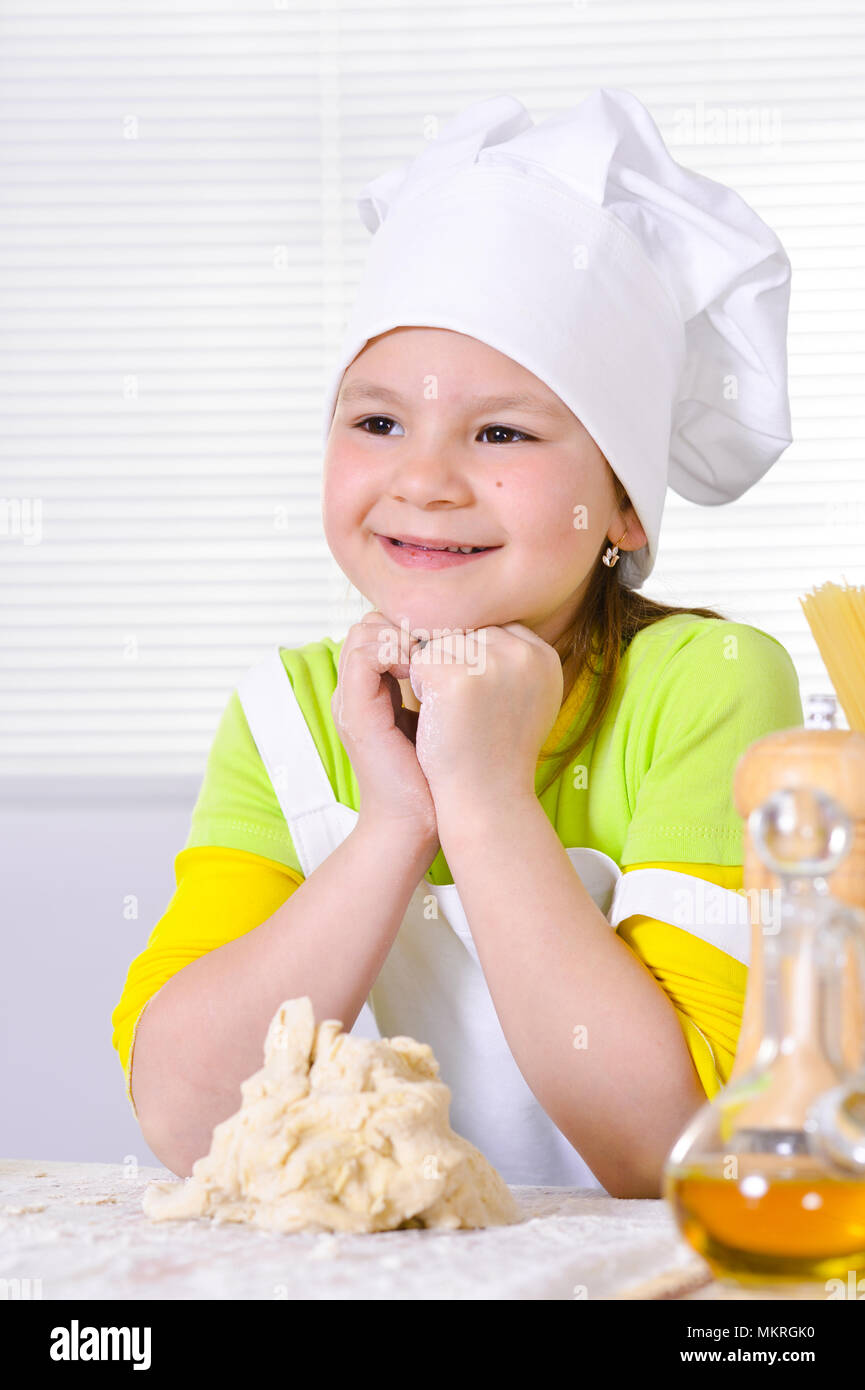 Cute little girl in chef's hat baking cake in the kitchen at home Stock ...