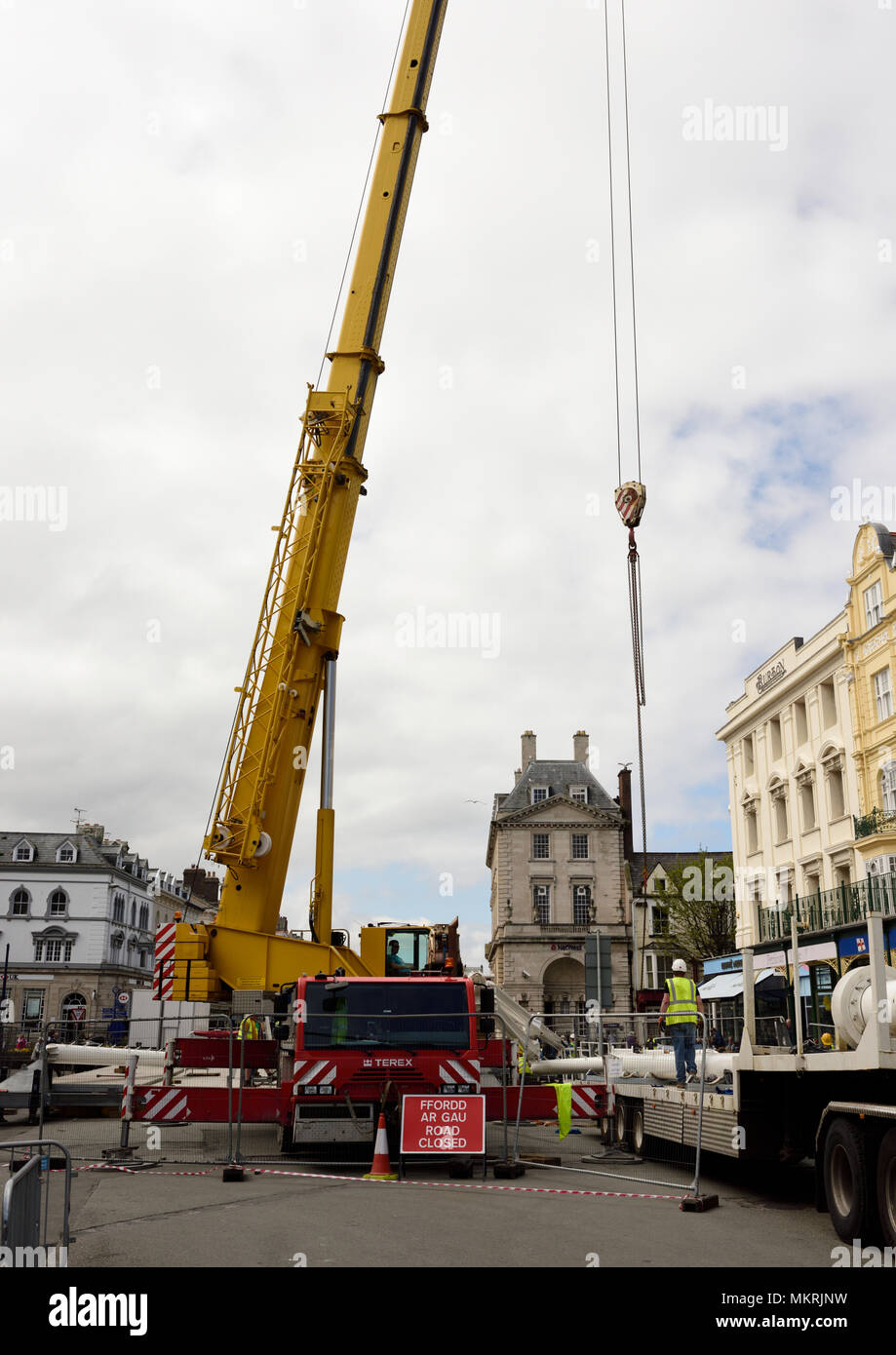 Mobile crane lowers lifting chains ready for riggers to secure to heavy ...