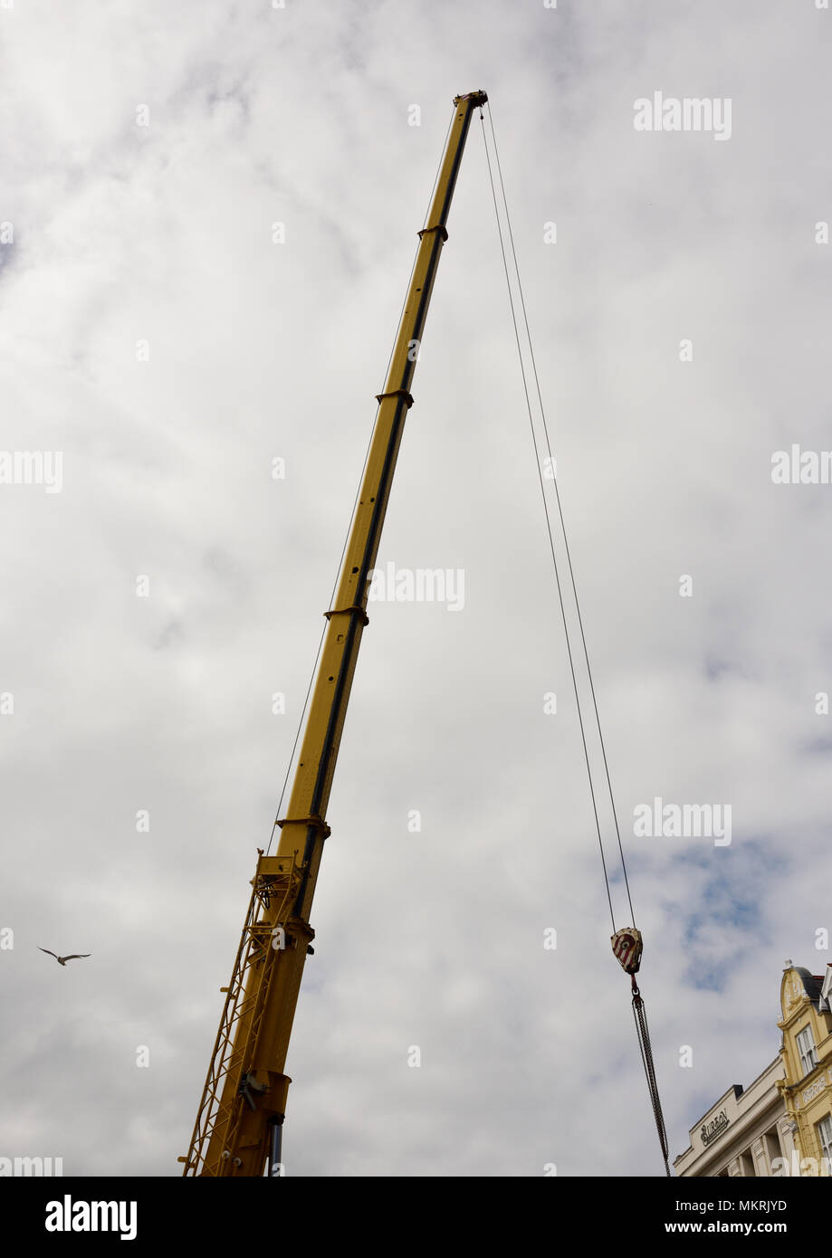 Mobile crane lowers lifting chains ready for riggers to secure to heavy ...