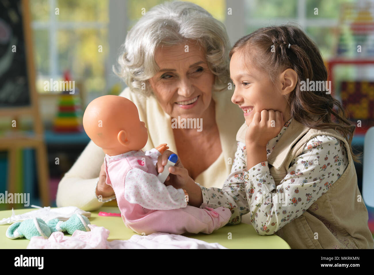 Portrait of grandmother and child play with baby doll Stock Photo - Alamy