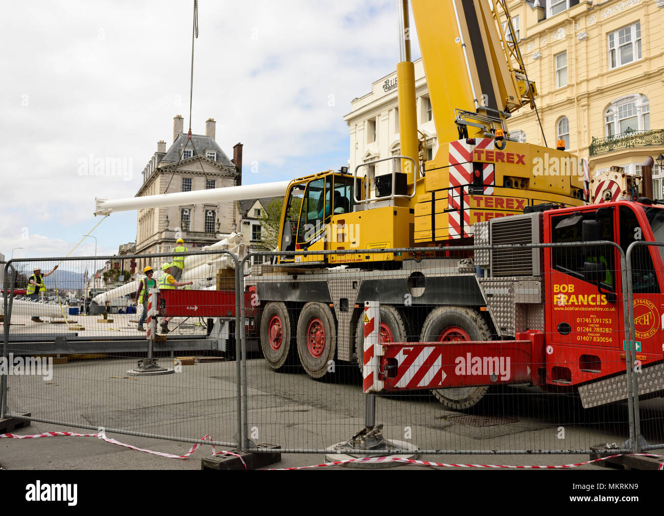 Mobile crane lowers heavy steel tube into position to assemble steel ...