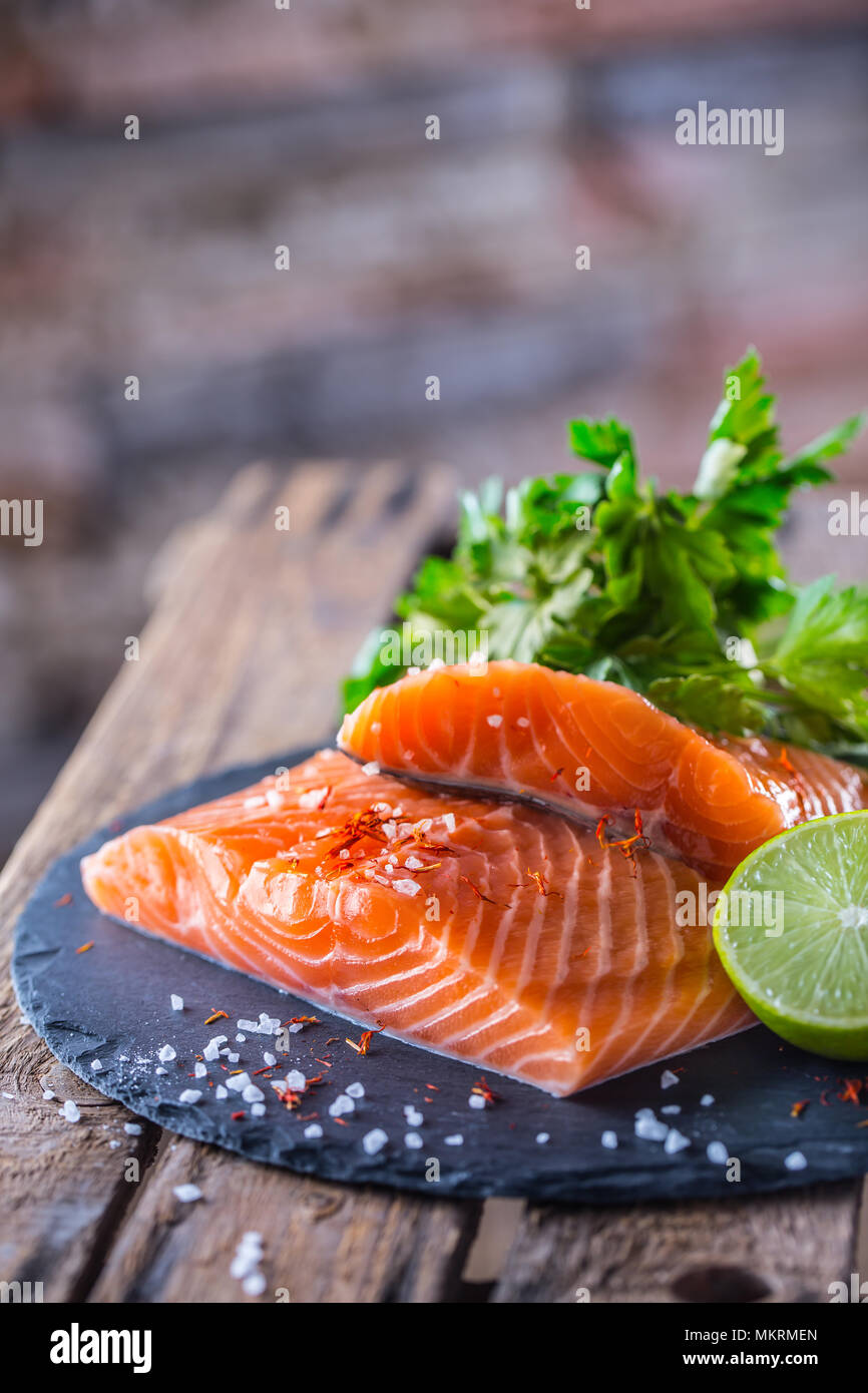 Raw salmon fillets with parsley herbs lime lemon salt and dried saffron ...