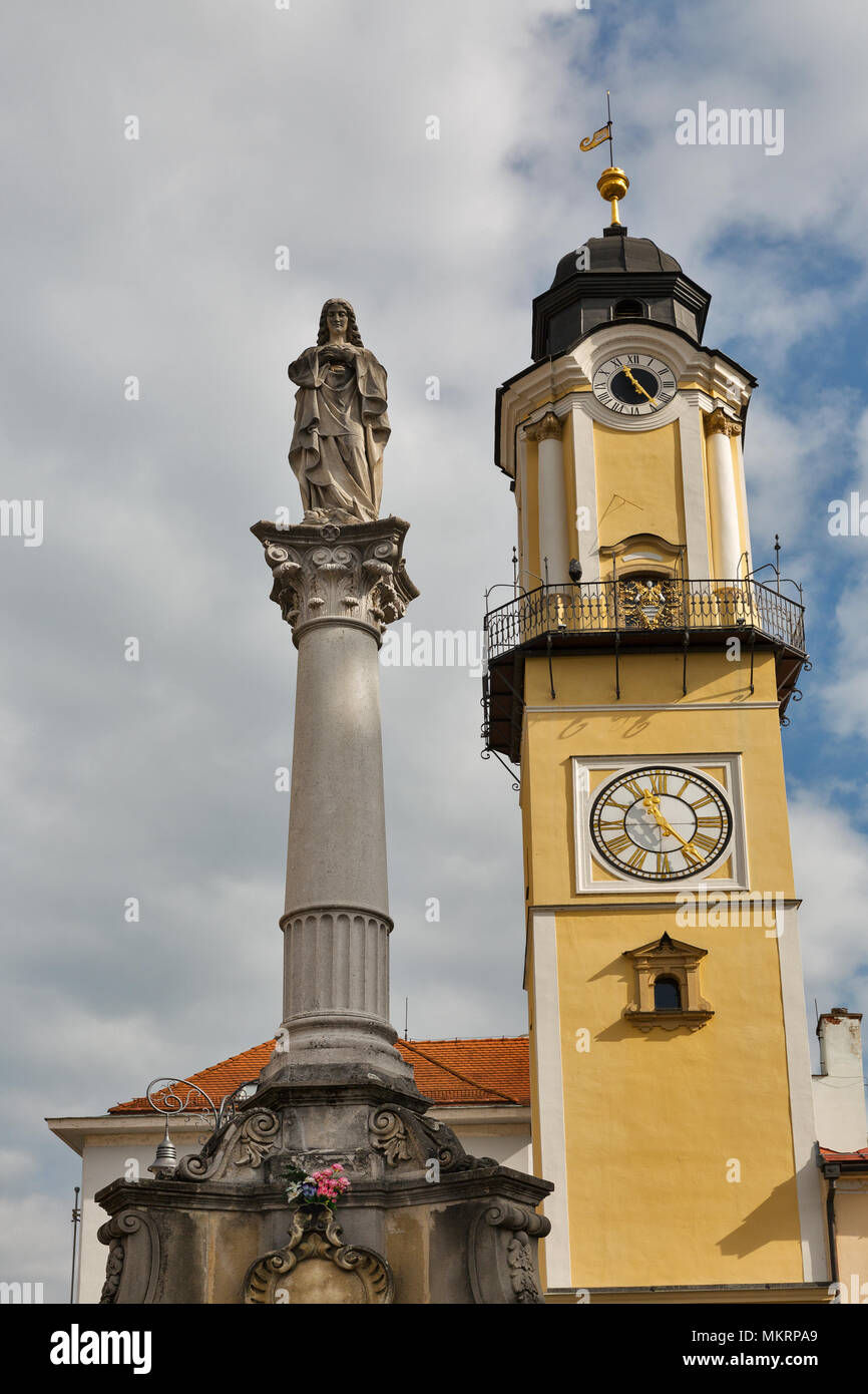 Virgin Mary statue on Baroque Marian column with Clock Tower in ...