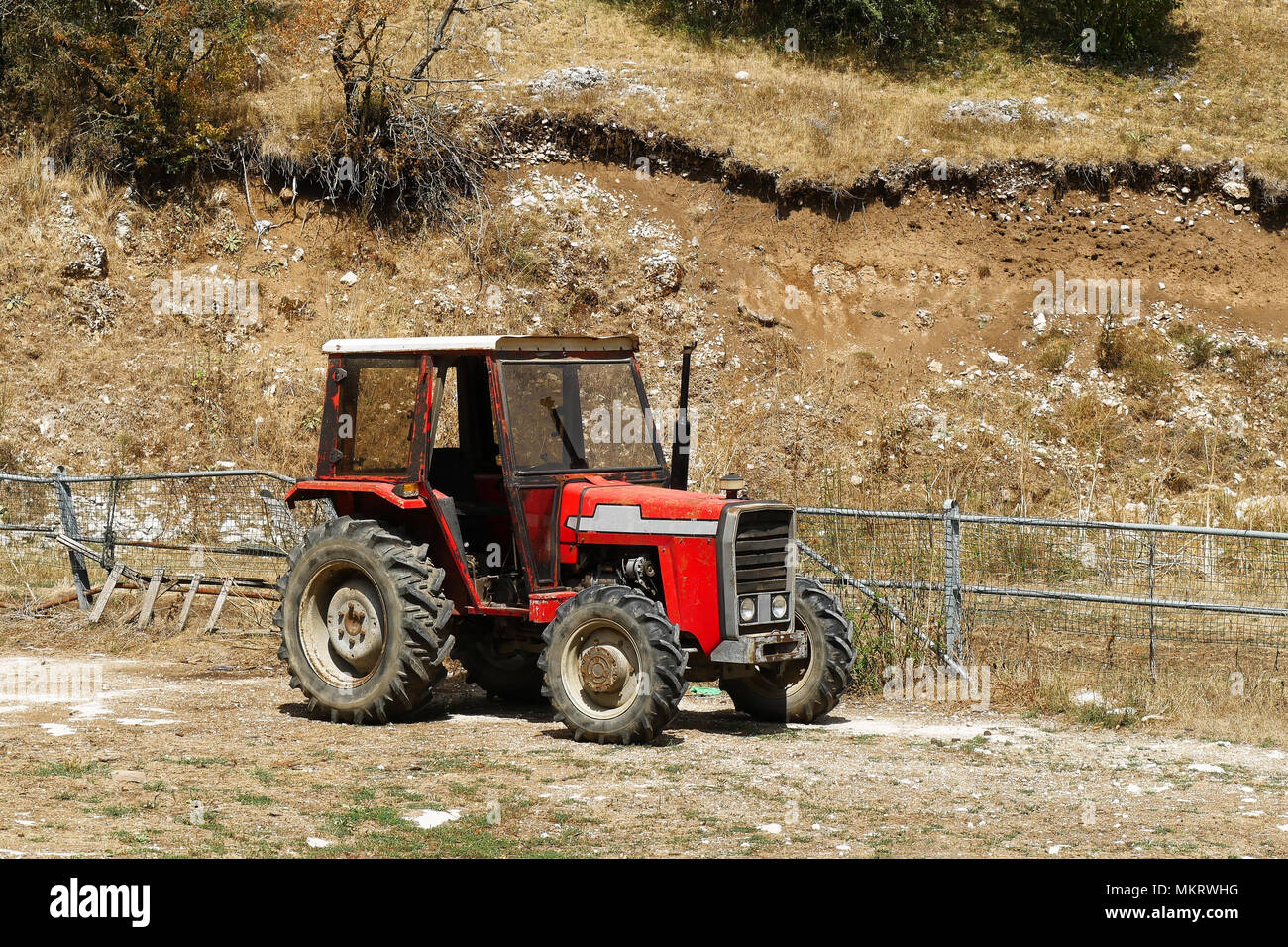 Red tractor in the field Stock Photo - Alamy