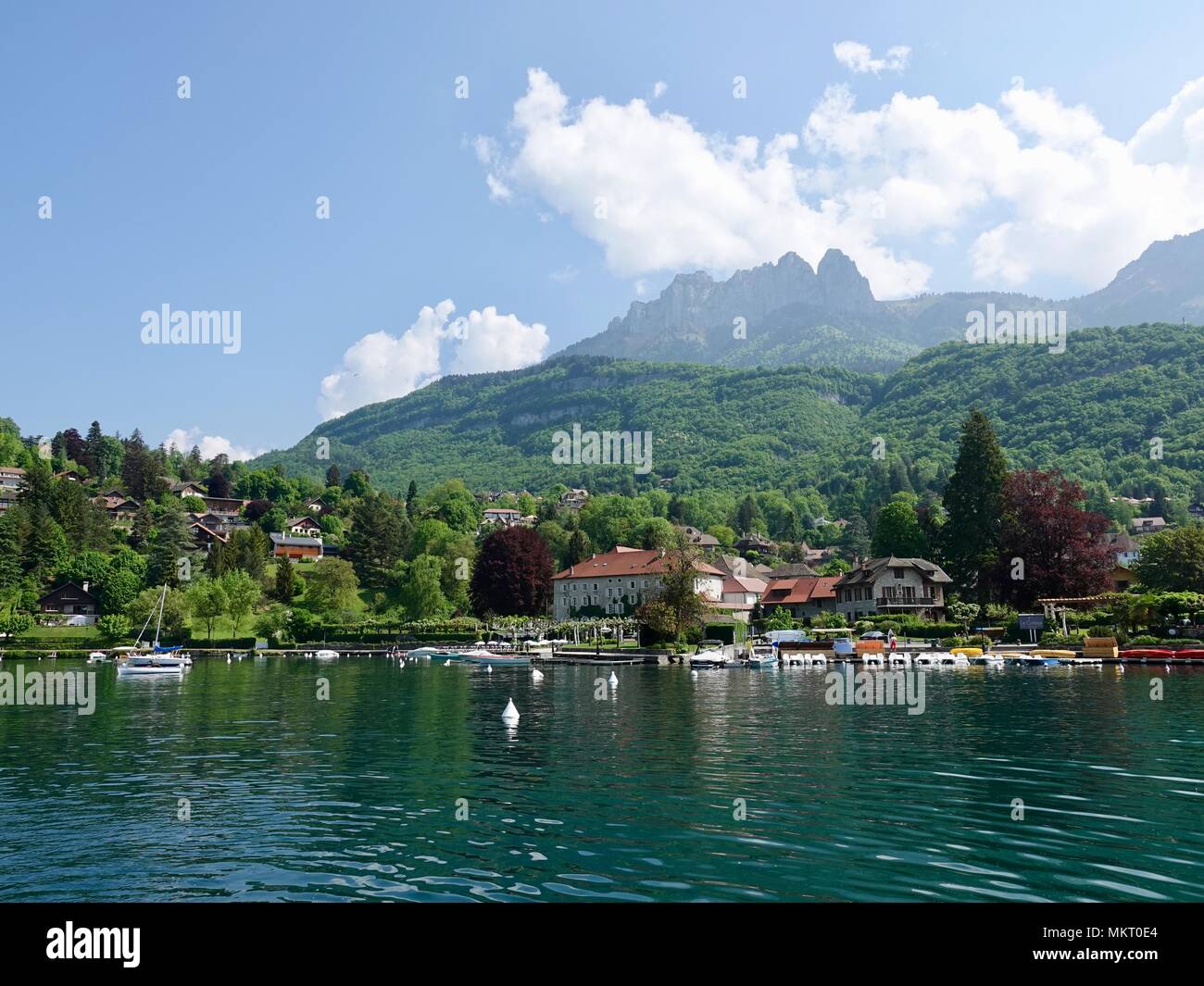 Lake Annecy, alpine lake with view of surrounding hillside homes and ...