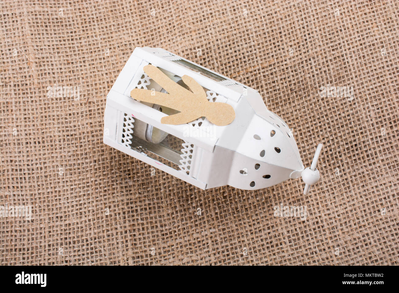 Man shape cut out of paper beside a lantern on canvas Stock Photo - Alamy