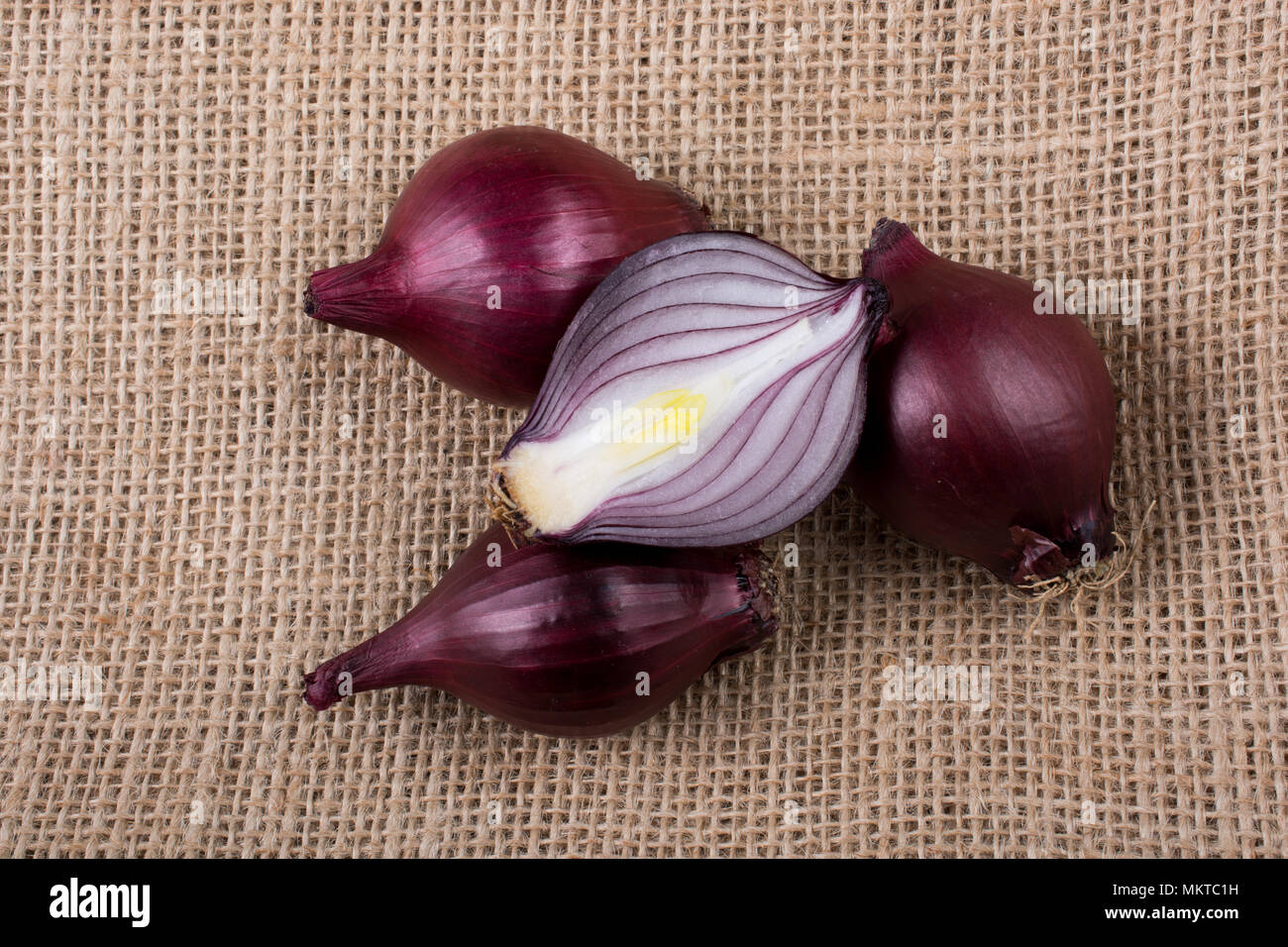 Red onion bulb cut in half on a certain background Stock Photo - Alamy
