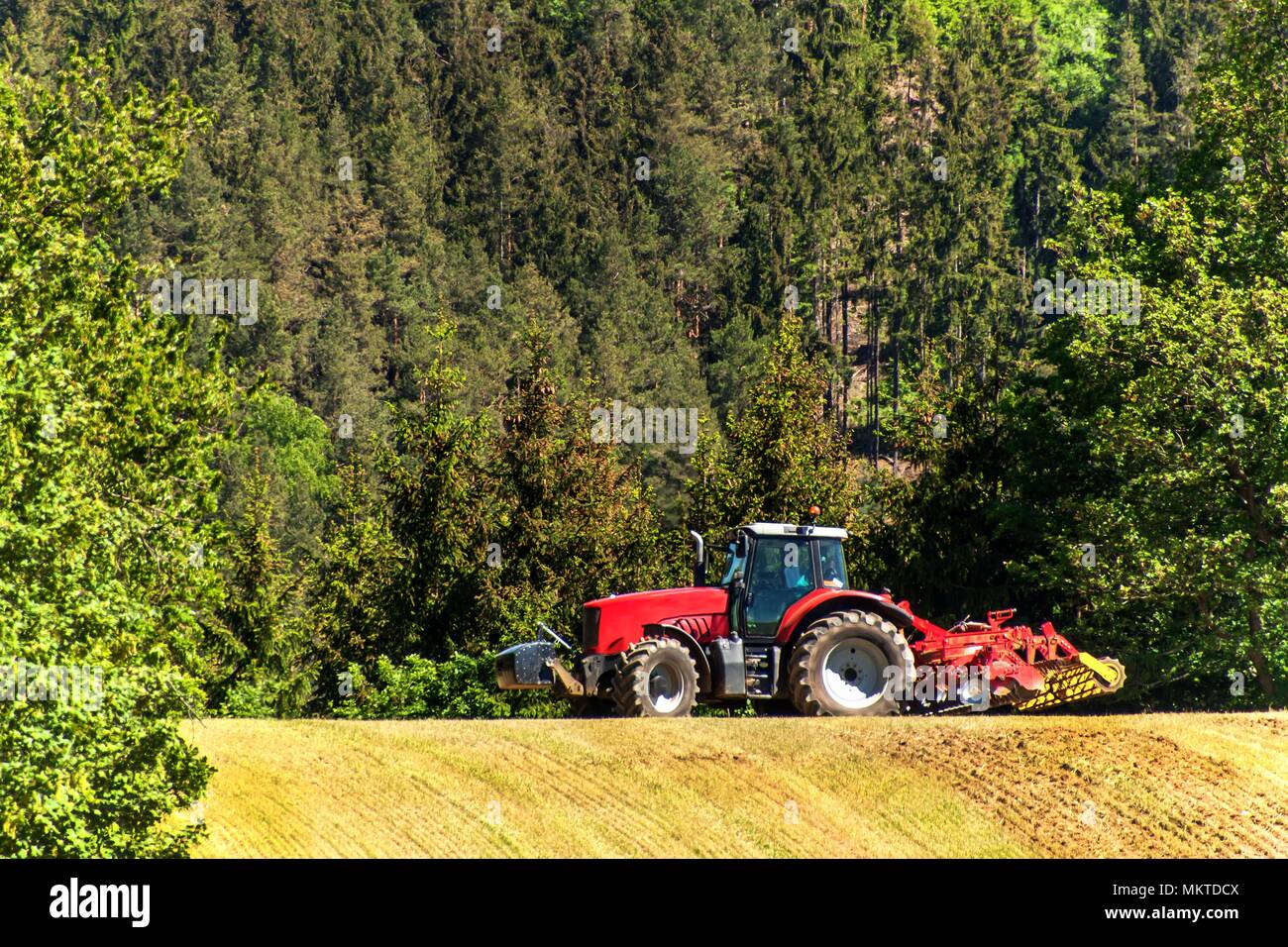 Field and operation of the tractor. Wind and dust over workers. Red ...
