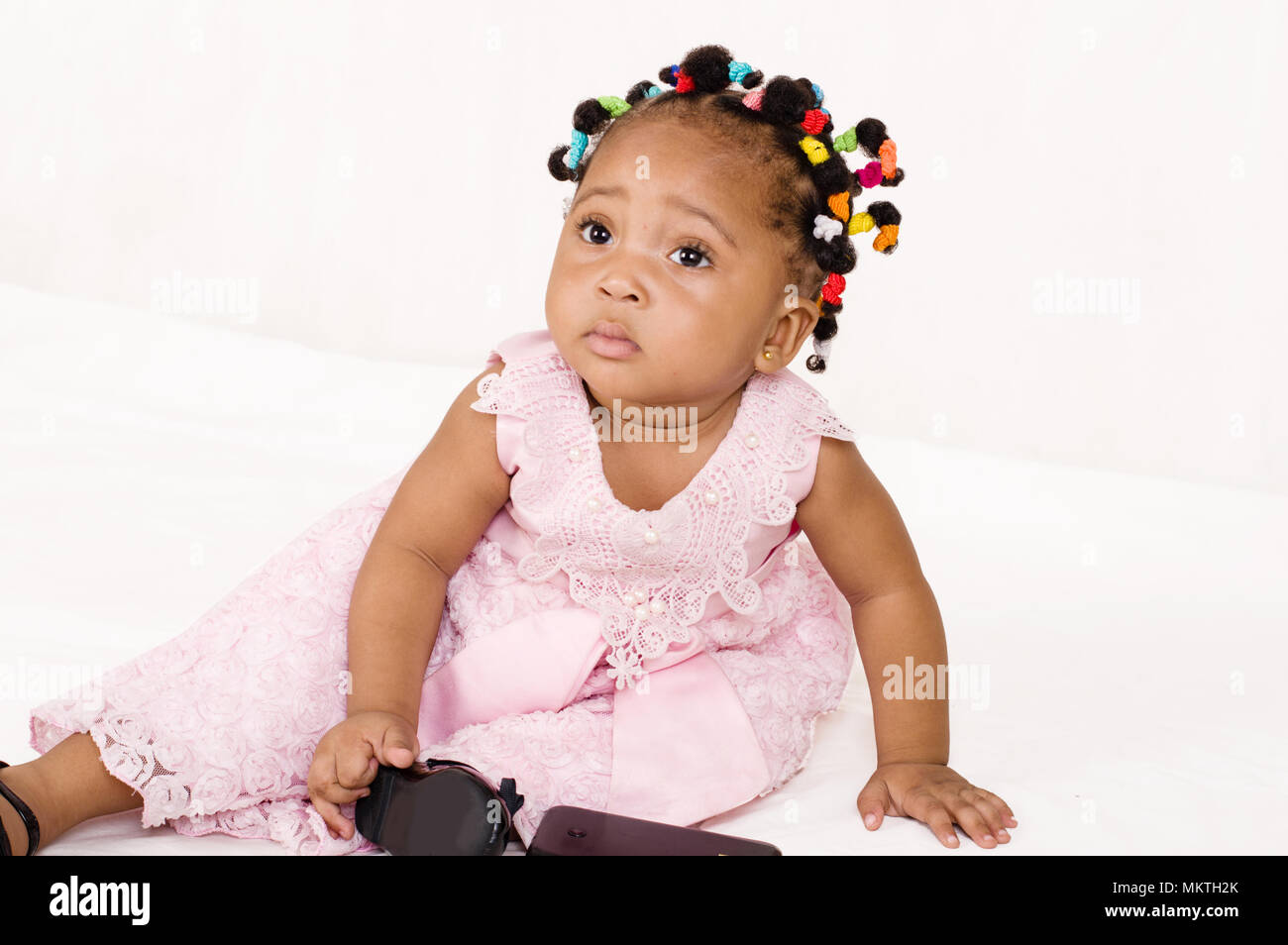 Pretty baby girl dressed well sitting isolated on white background ...
