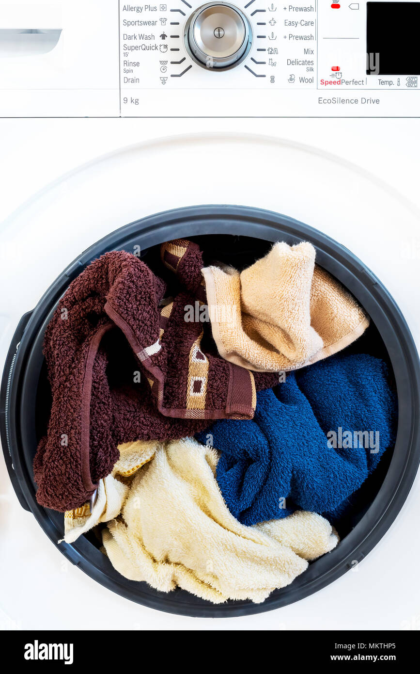 A close up of a washing machine loaded with clothes Stock Photo - Alamy