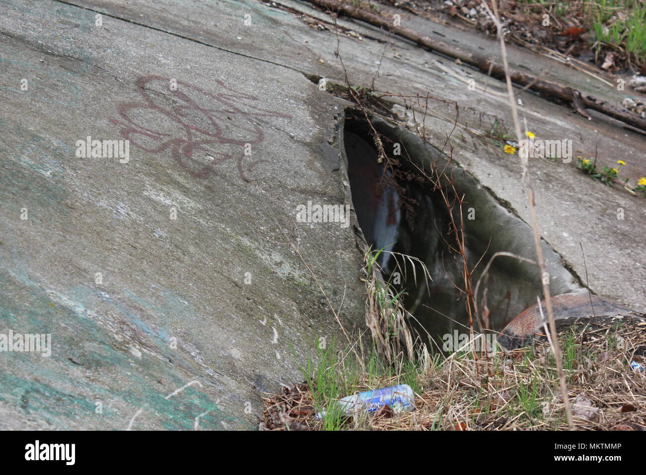 Spray painted graffiti next to a water intake pipe and culvert Stock ...