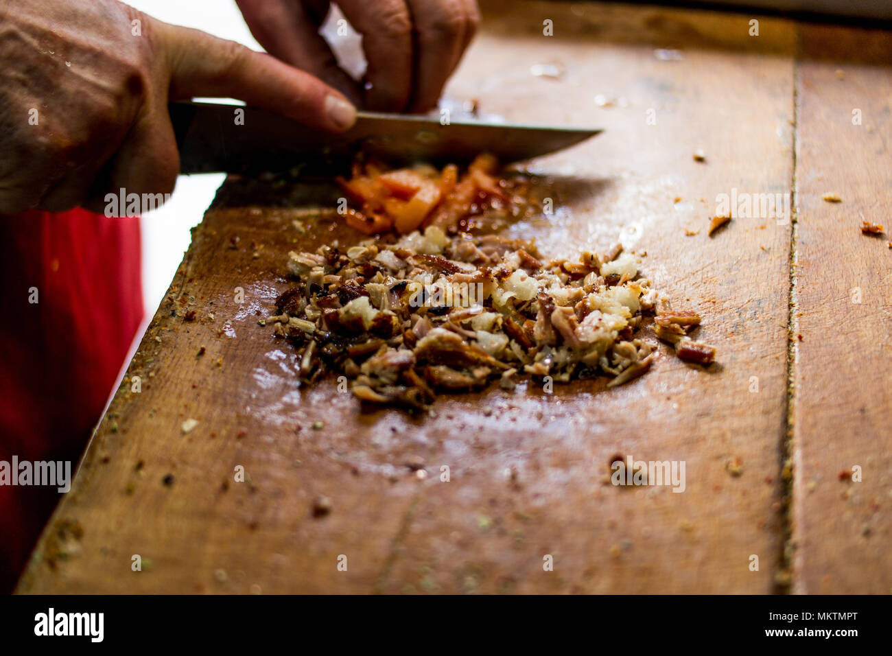Man is preparing kokorec (fried sheep bowel) with tomato and spices ...