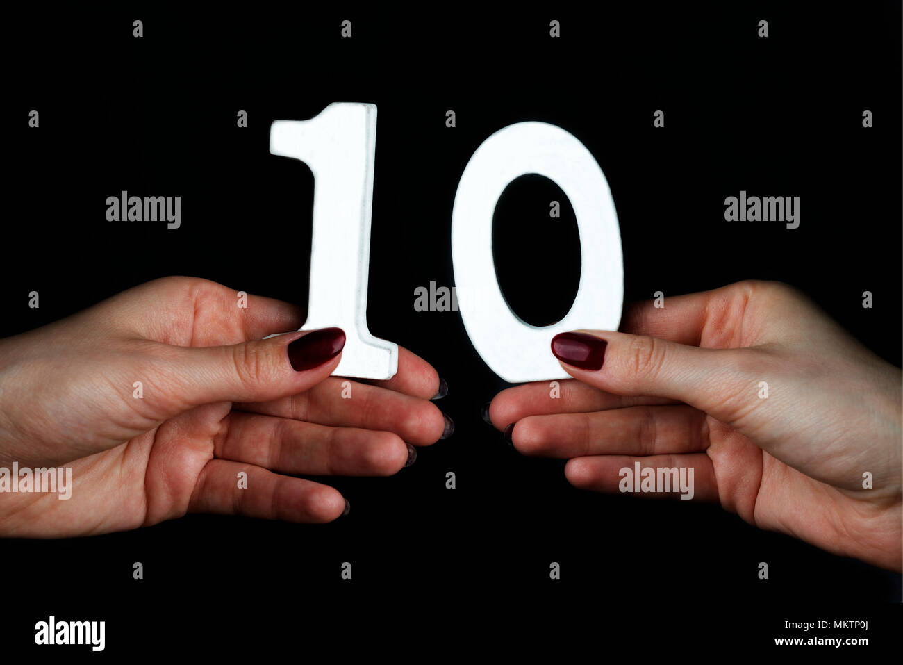 On a black background, female hand with number ten Stock Photo - Alamy