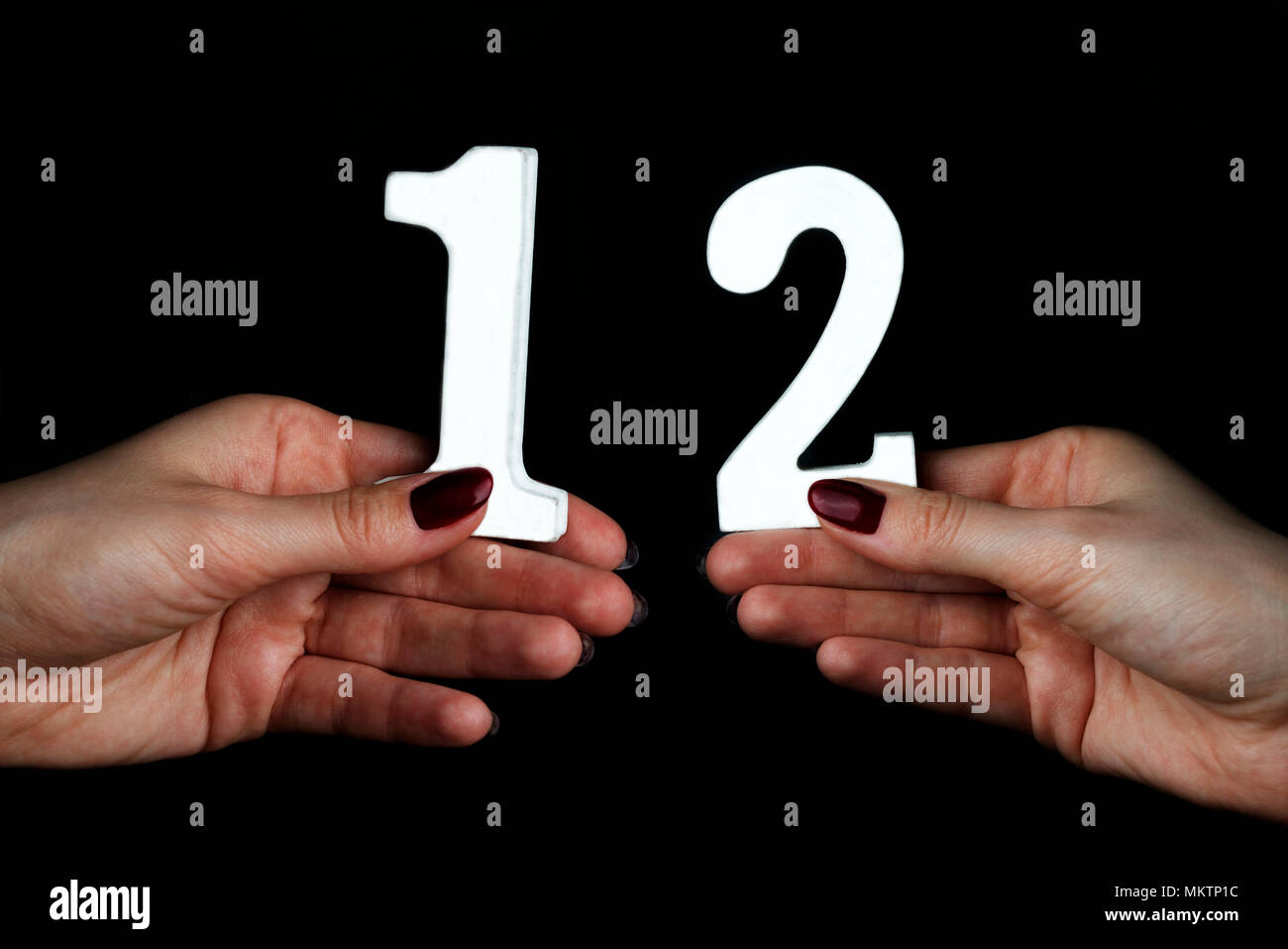 On a black background, female hand with numeral twelve Stock Photo - Alamy