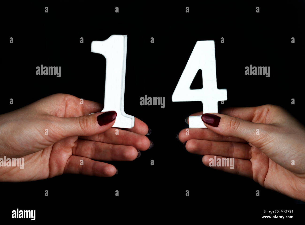 On black background female hands with number fourteen Stock Photo - Alamy