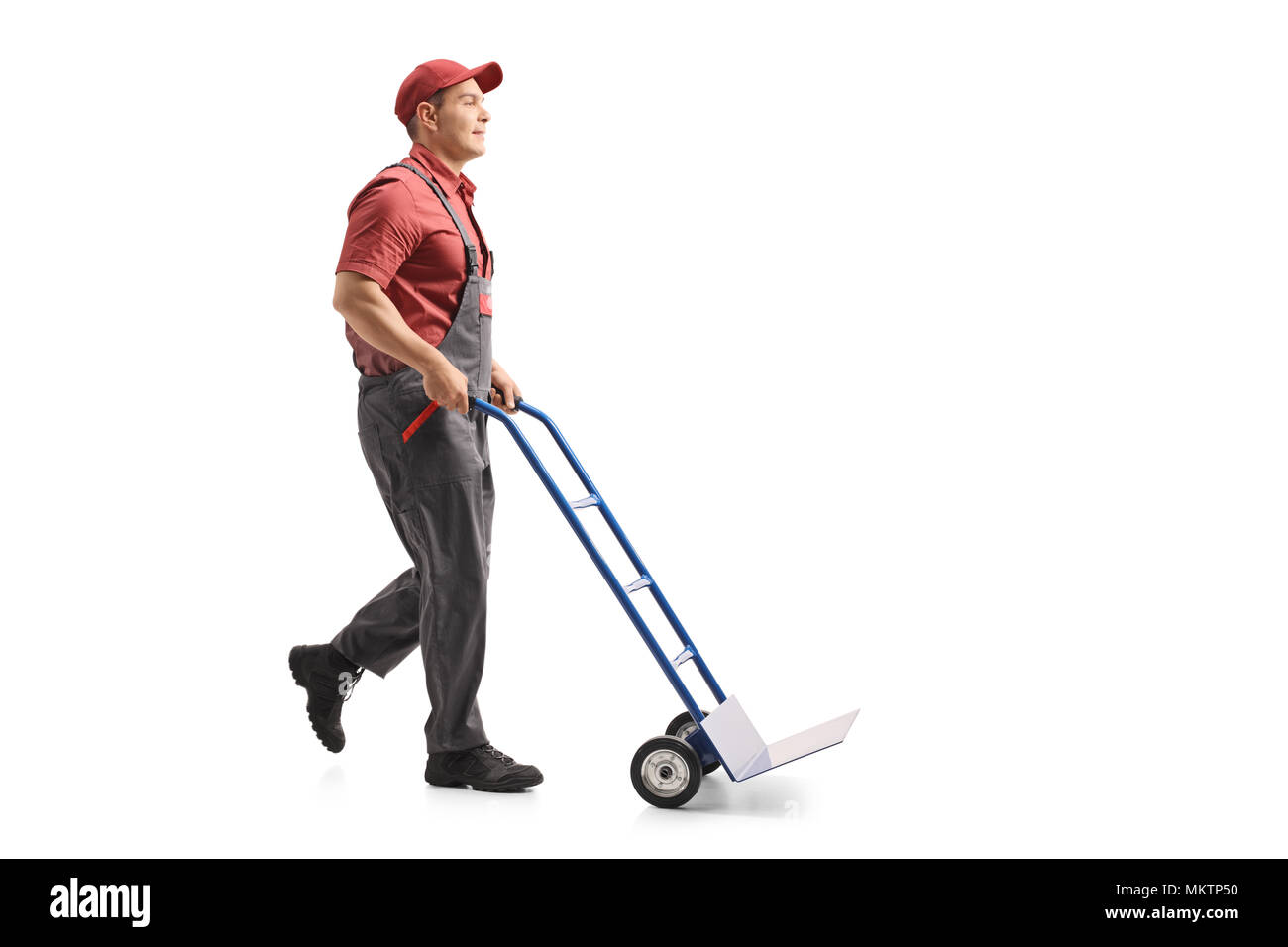 Full length profile shot of a mover pushing an empty hand truck ...