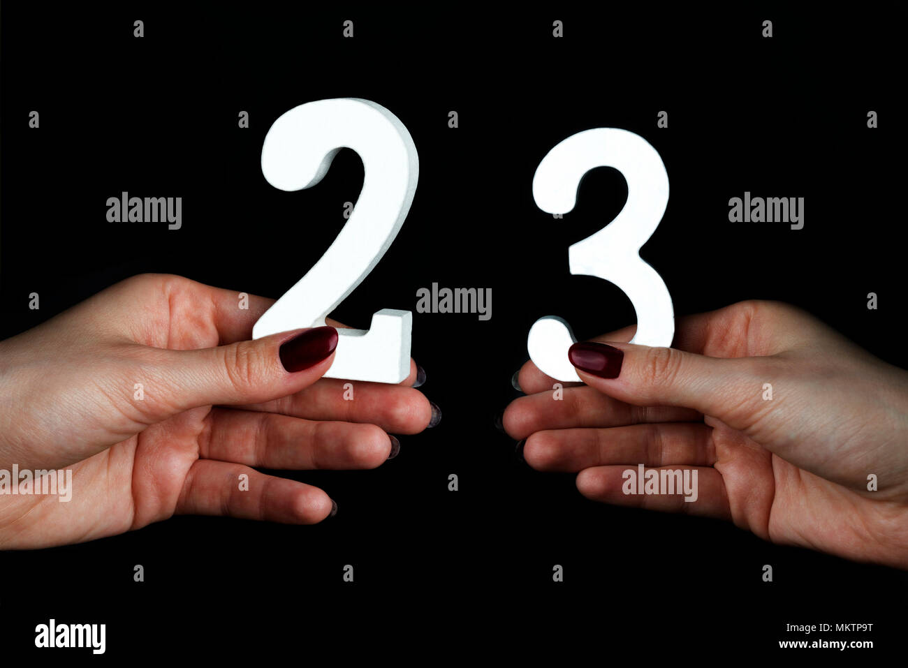 On a black background, female hand with number twenty-three Stock Photo ...